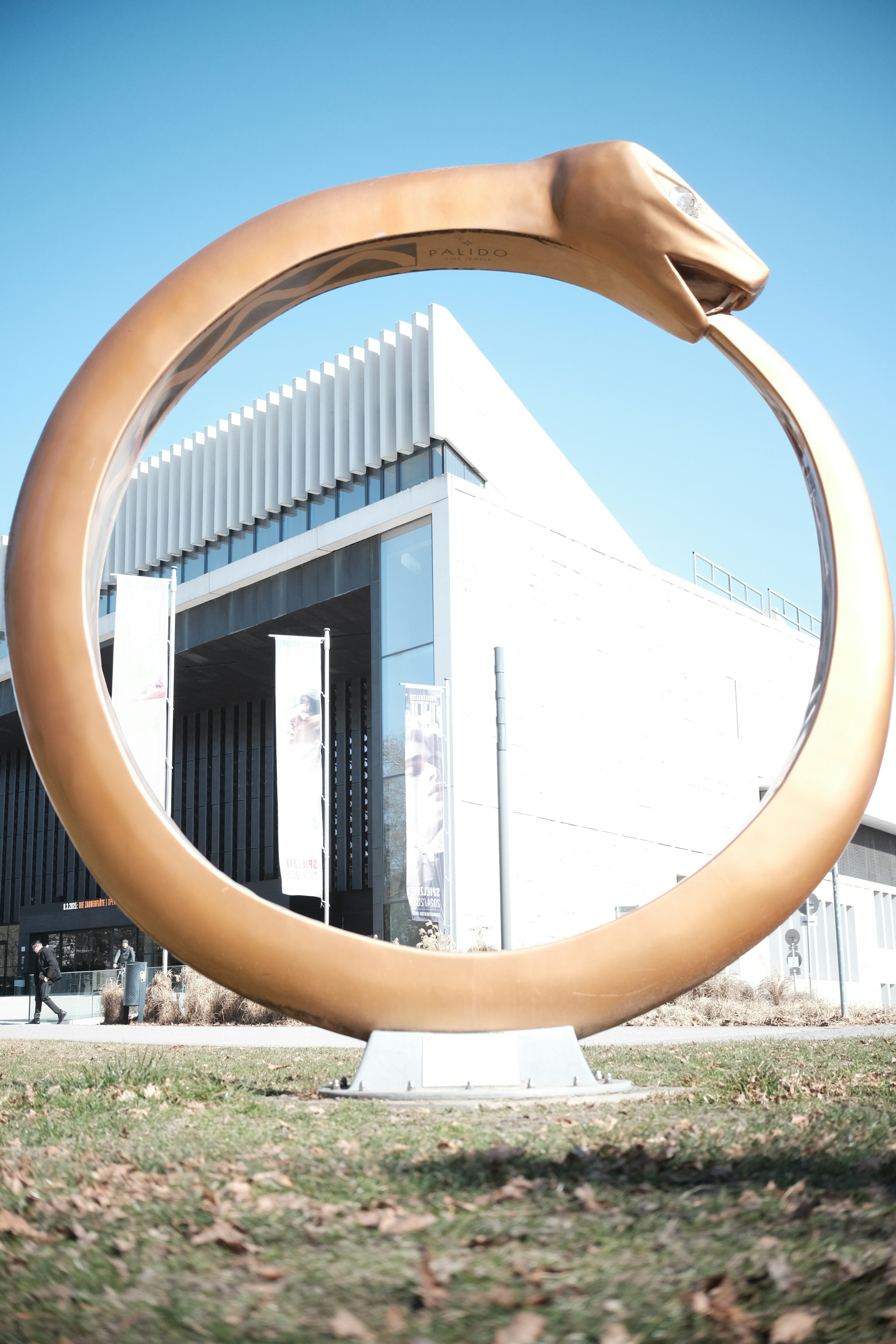 An ouroboros sculpture frames a modern building. photo – Free Art Image ...