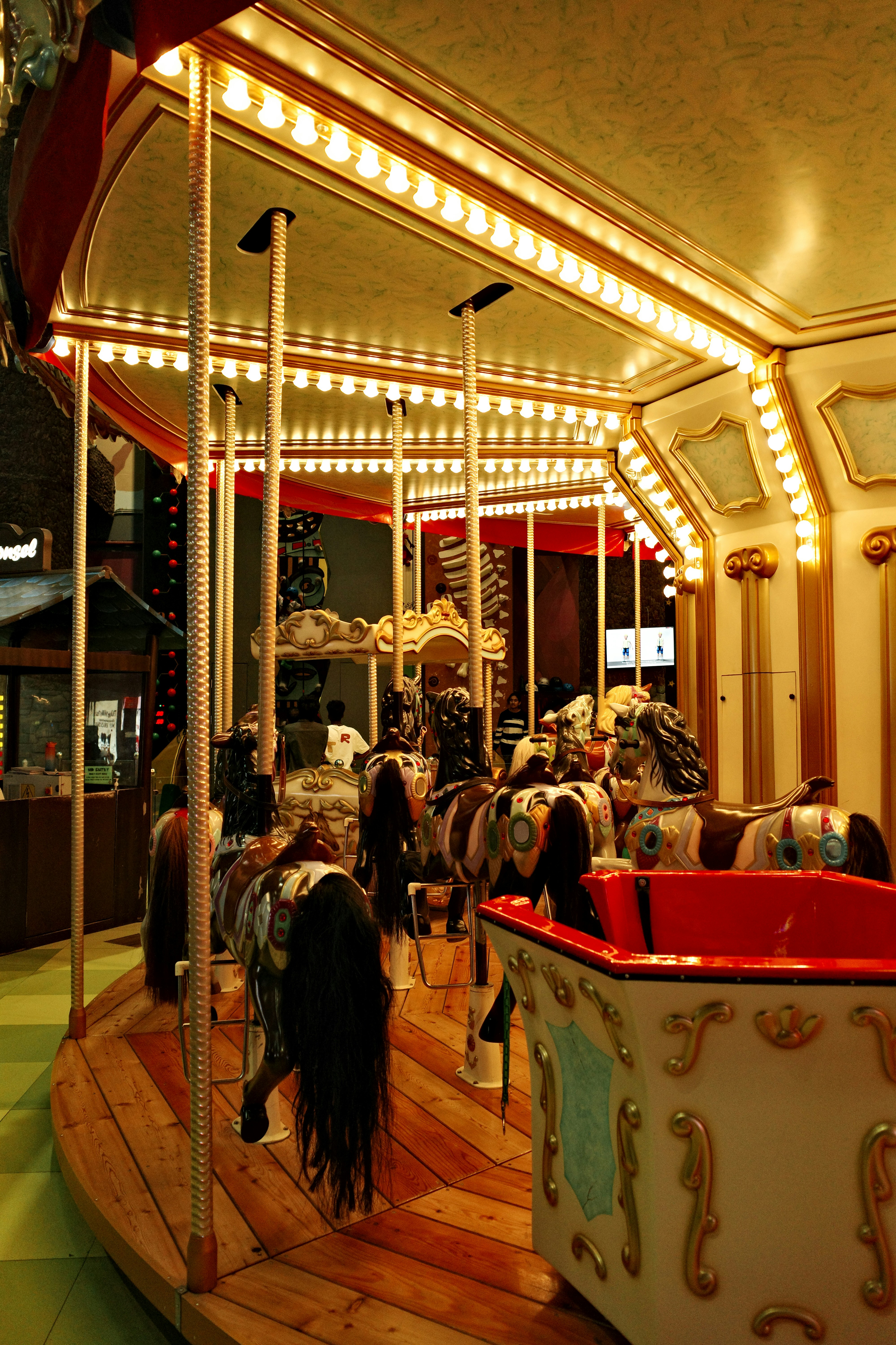 Glow-Wrapped Carousel: Neon Canopy and Painted Horses Under Warm Indoor Lights