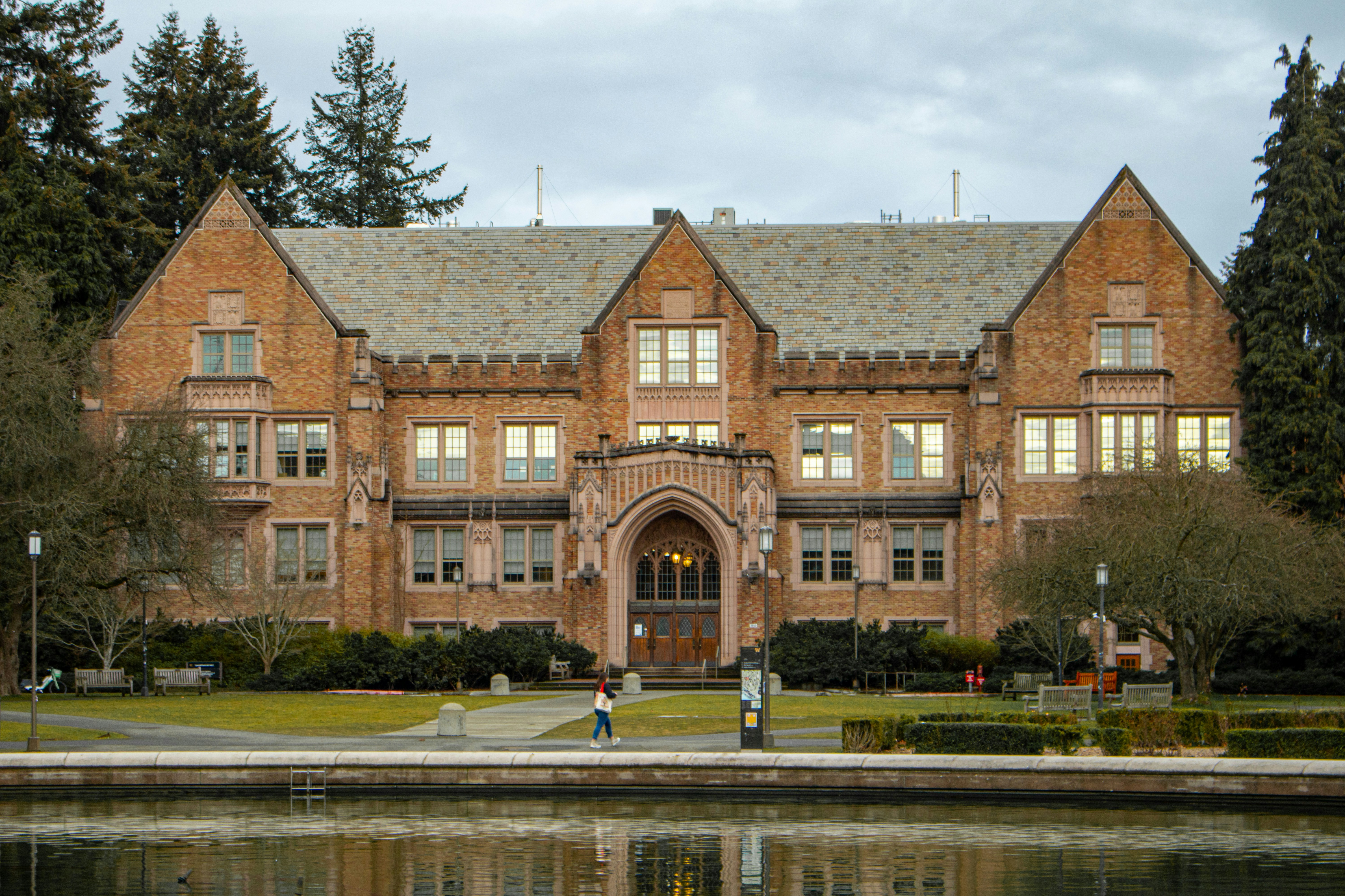 A beautiful brick building is by water. photo – Free Building Image on ...