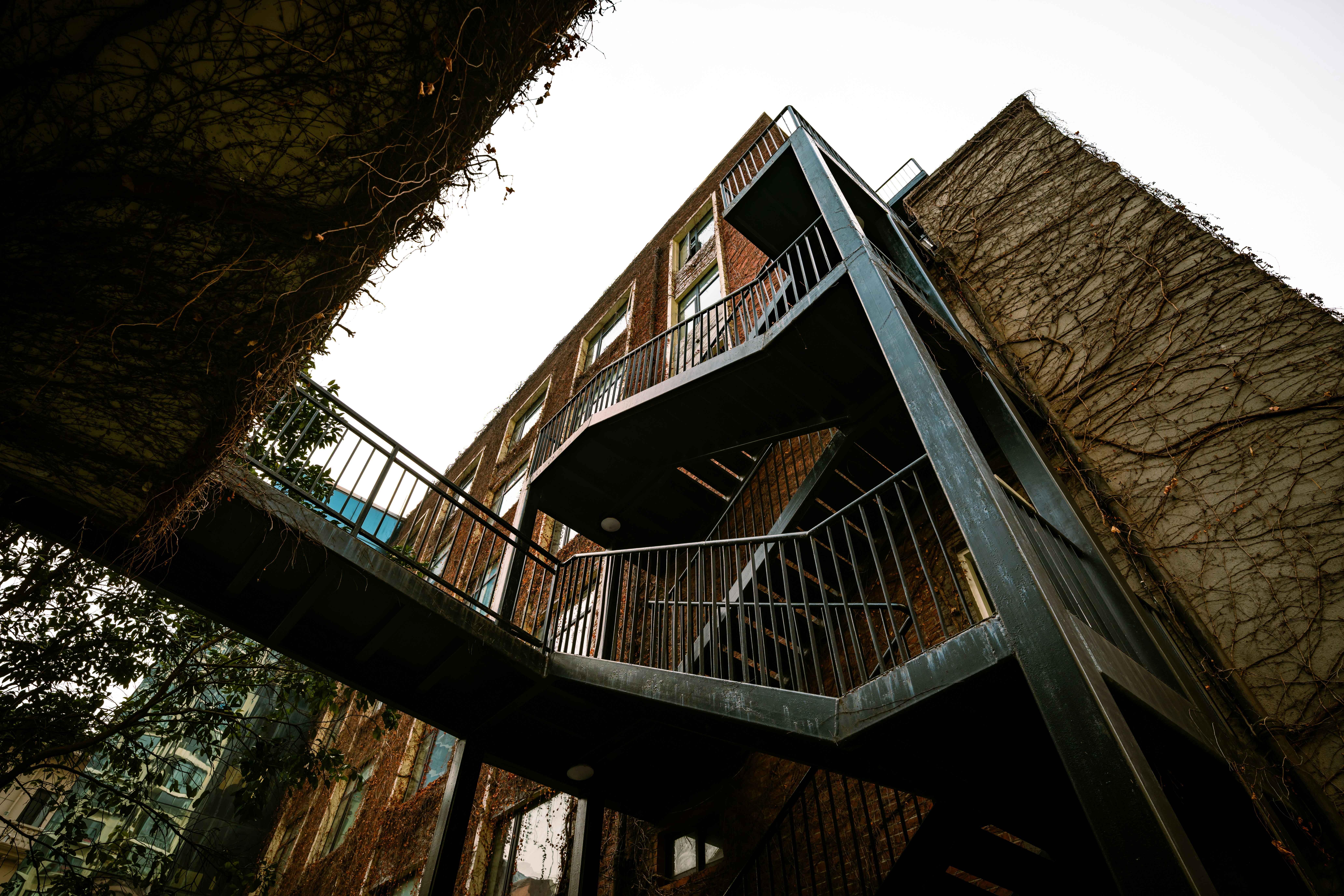 Modern outdoor staircase winding along a brick building facade.