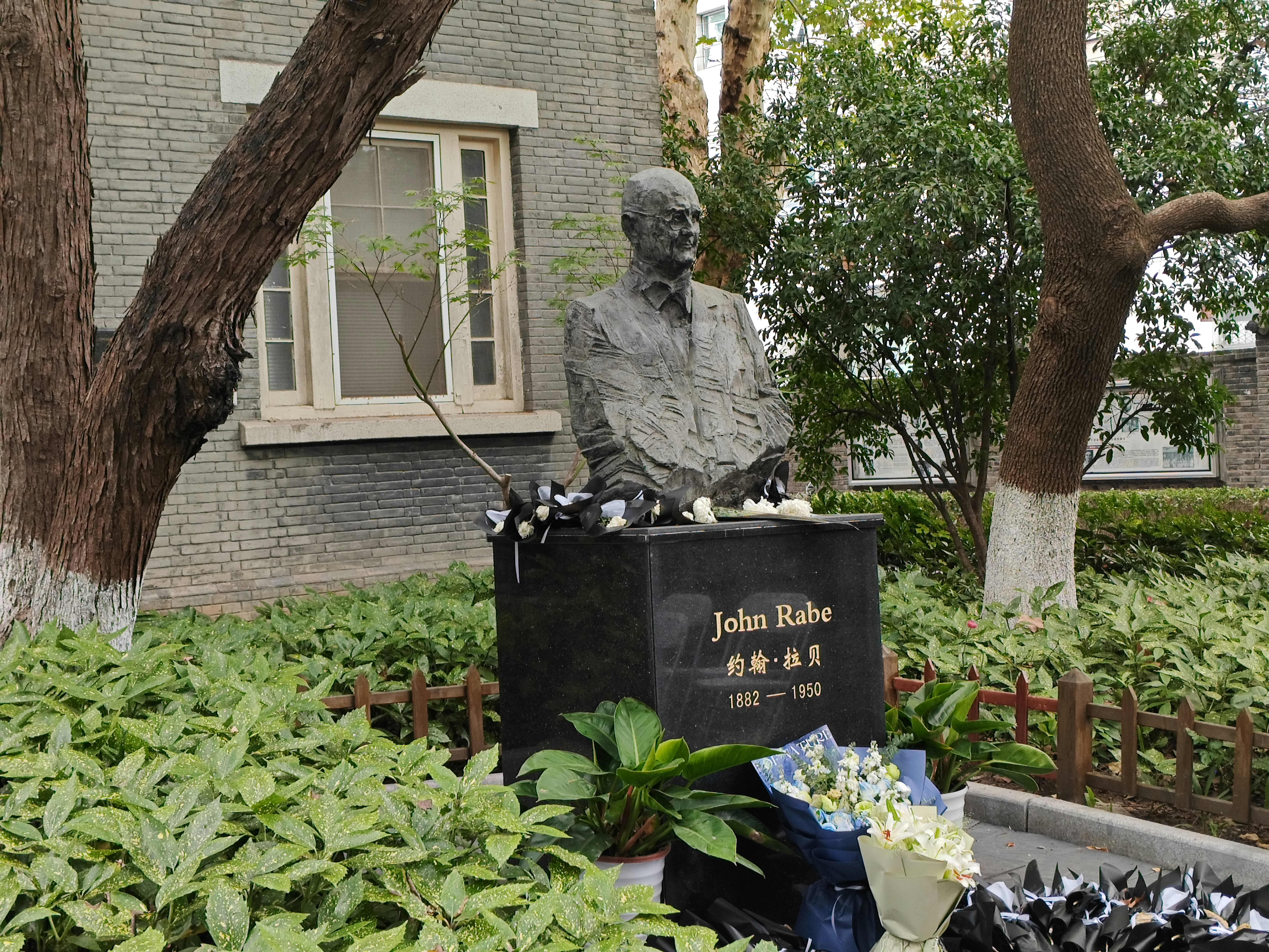 A statue of john rabe stands outdoors. photo – Free China Image on Unsplash
