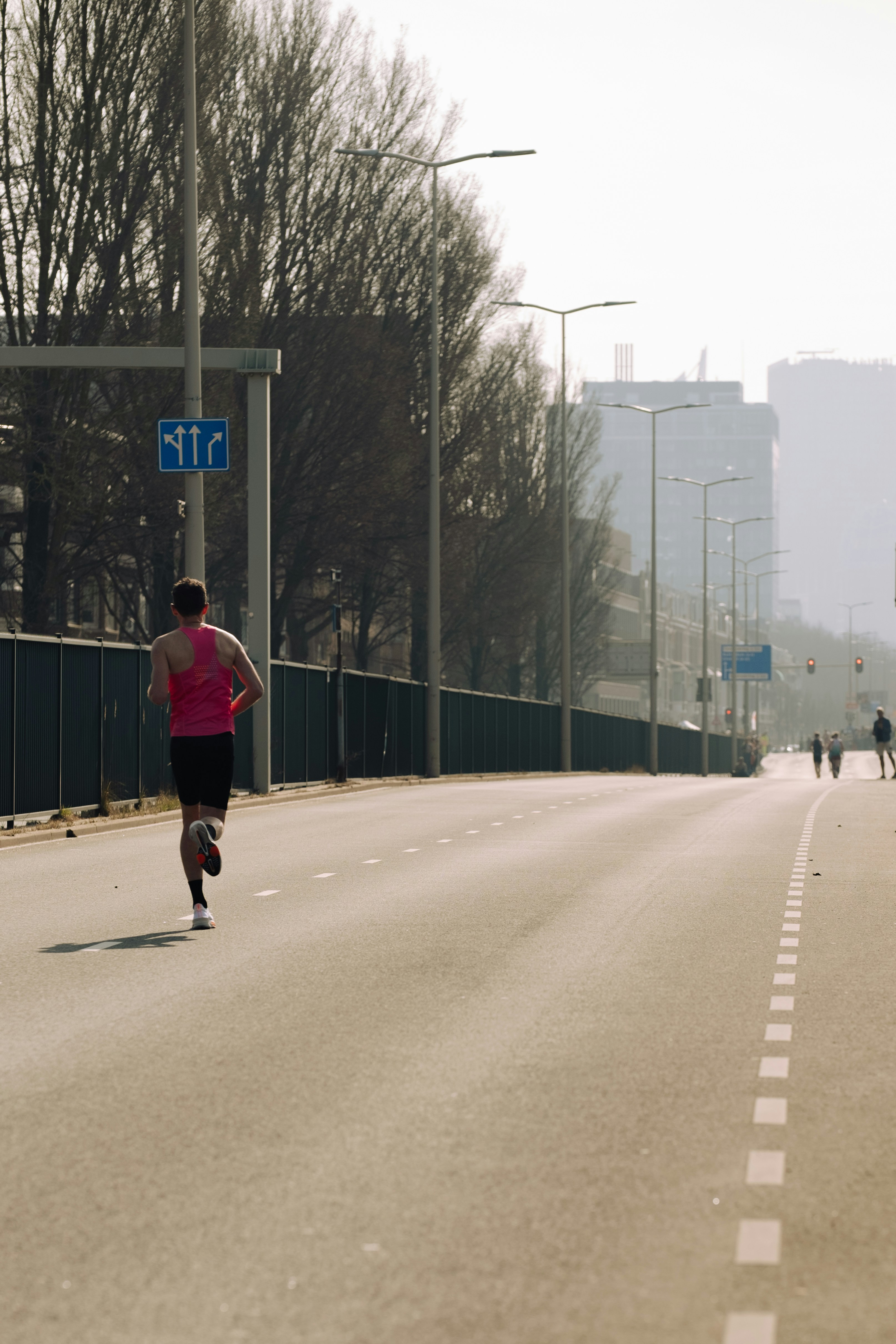 A lone runner sprints down a long, empty road. photo – Free Running ...