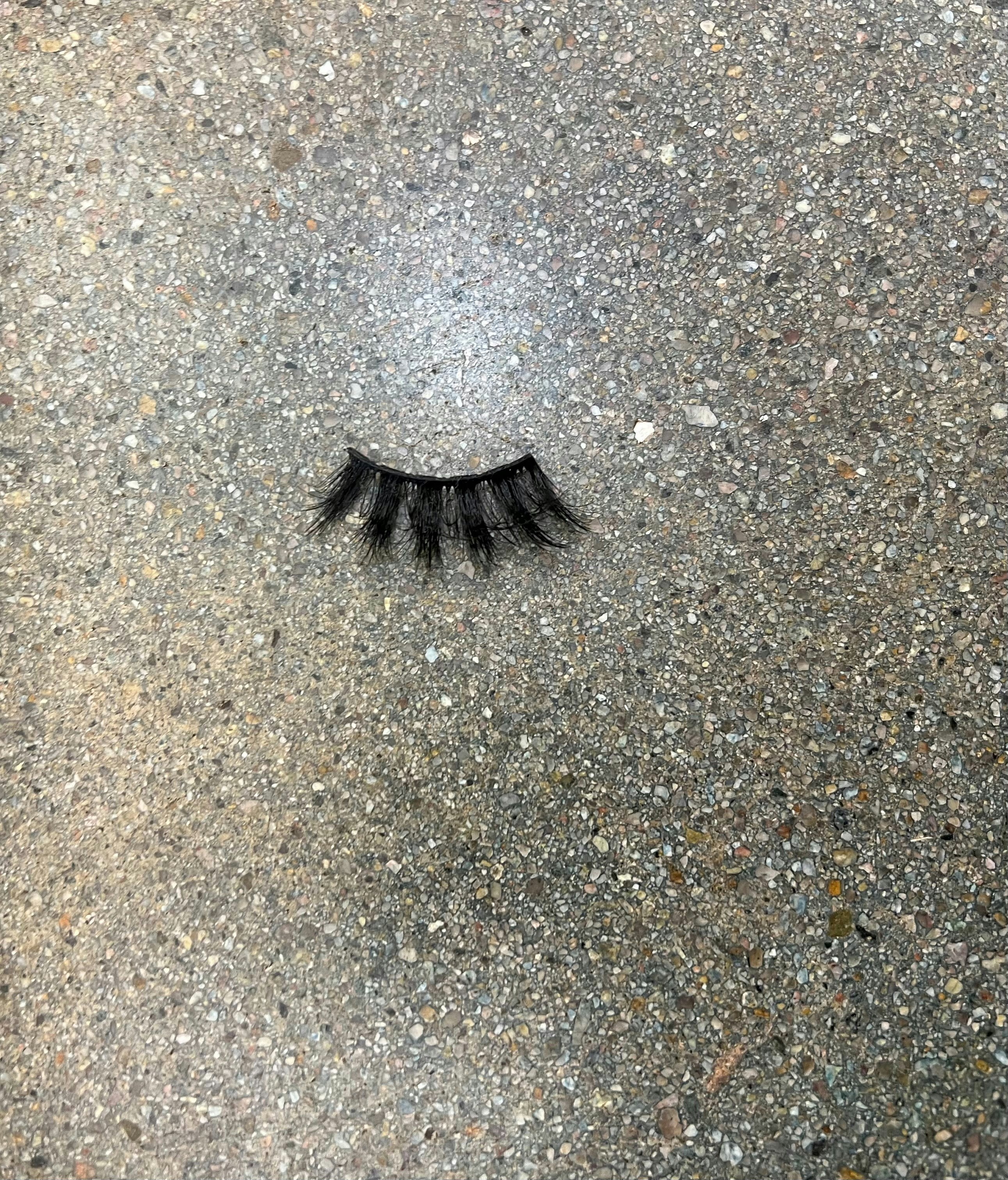 Lone eyelash on rough pavement: a micro-world revealed