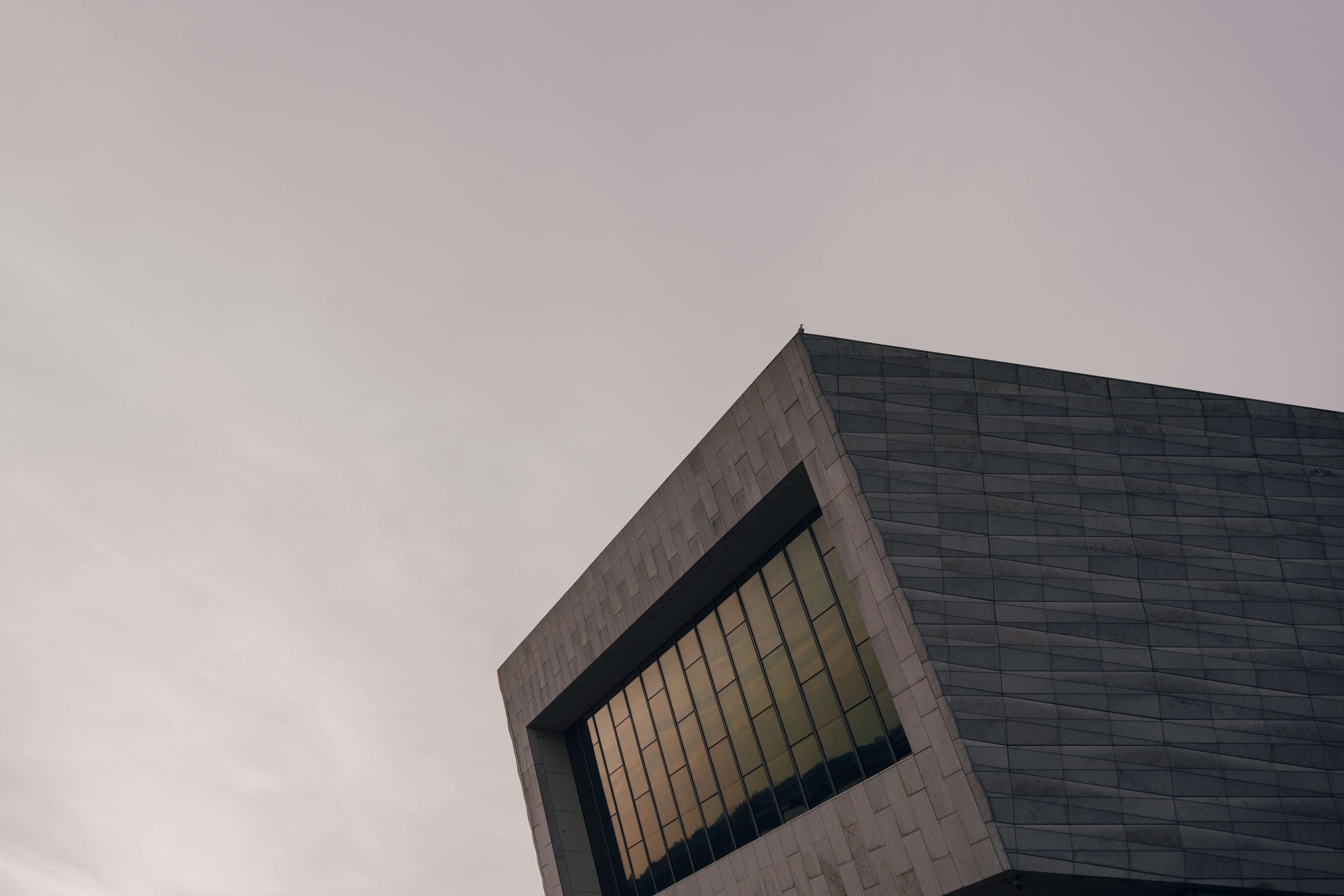 A modern, angular building with a large window. photo – Free Building ...