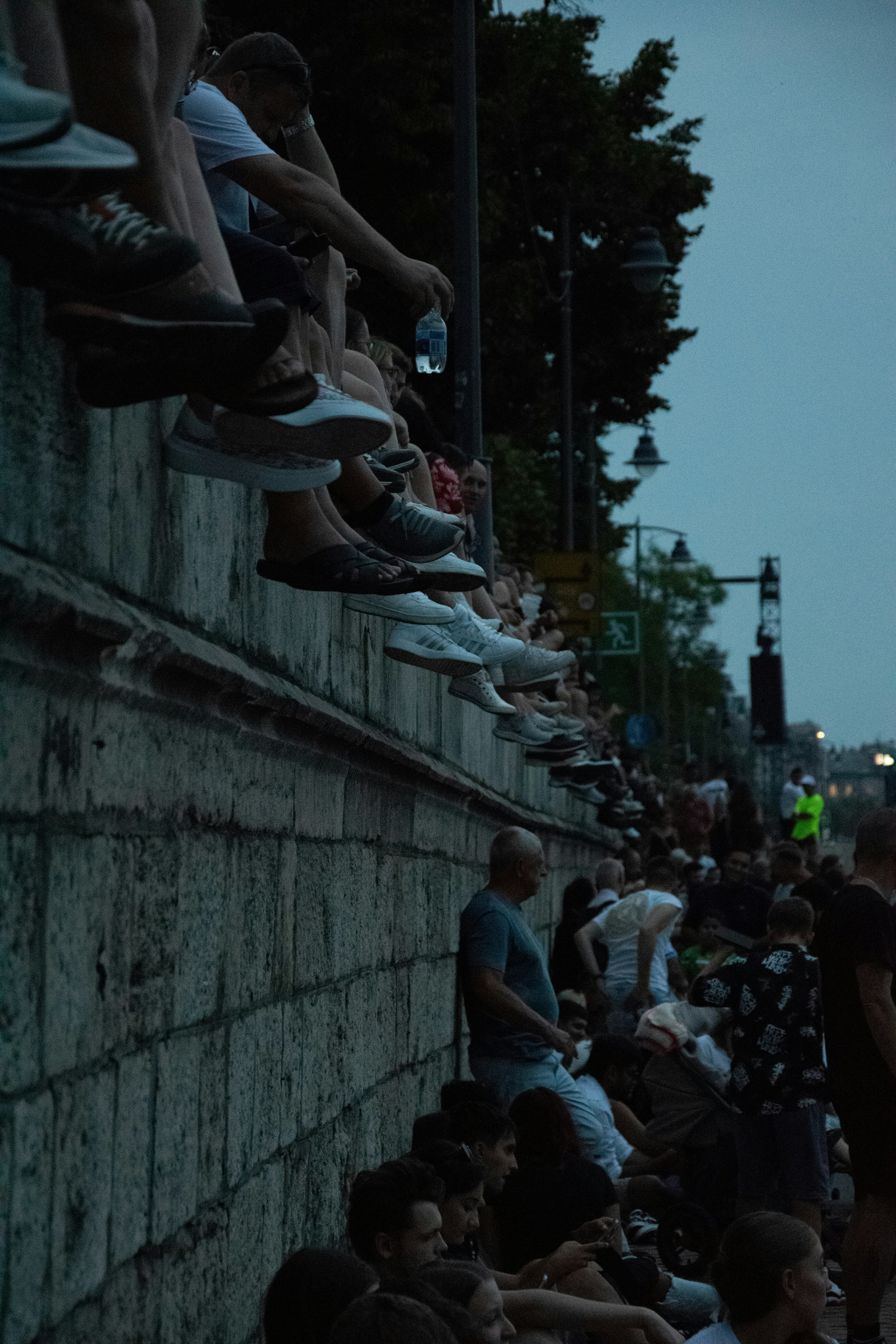 Concrete ledge, crowded ascent: evening spectators line the wall