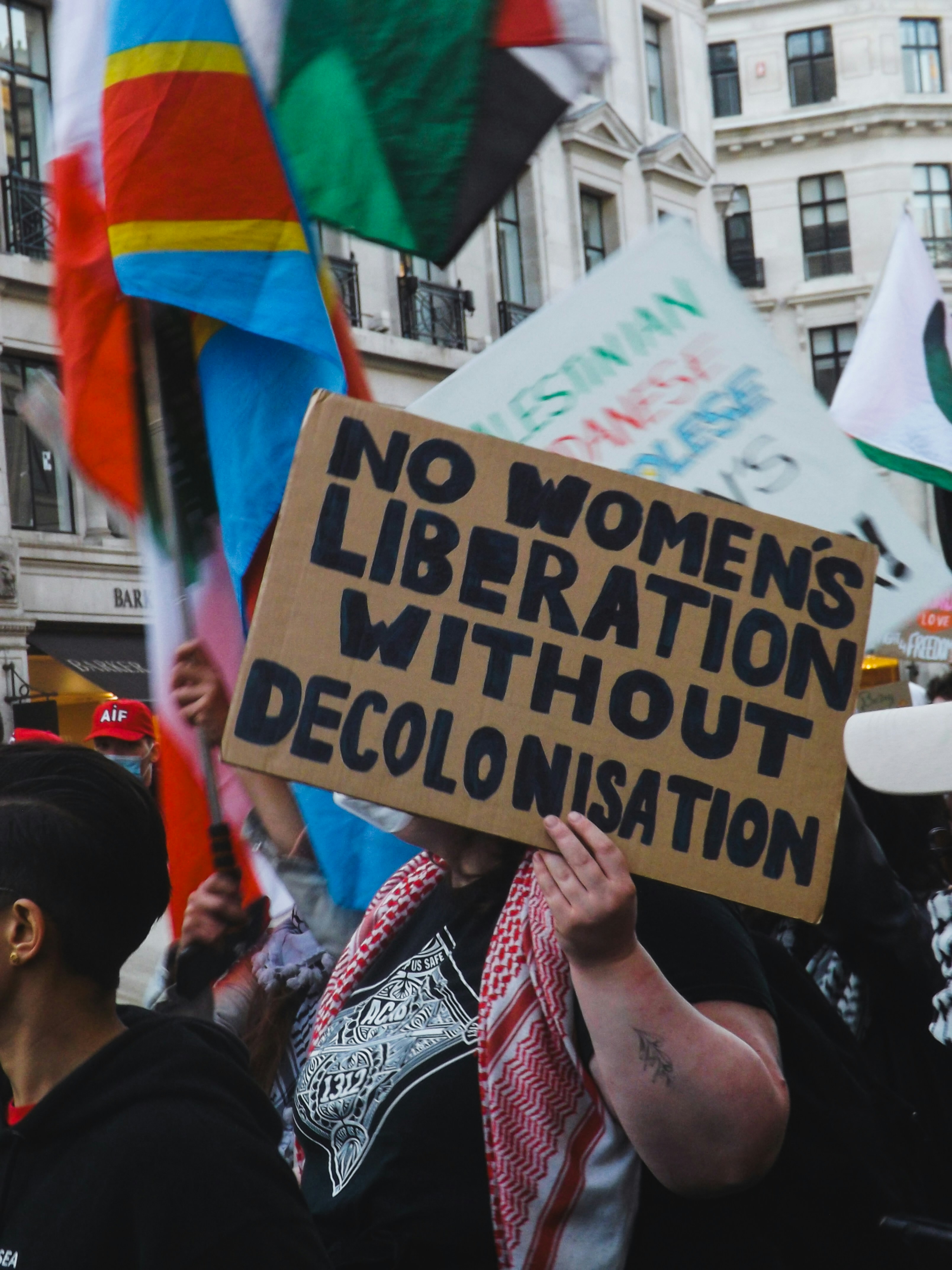Protesters hold signs about decolonization and liberation. photo – Free ...