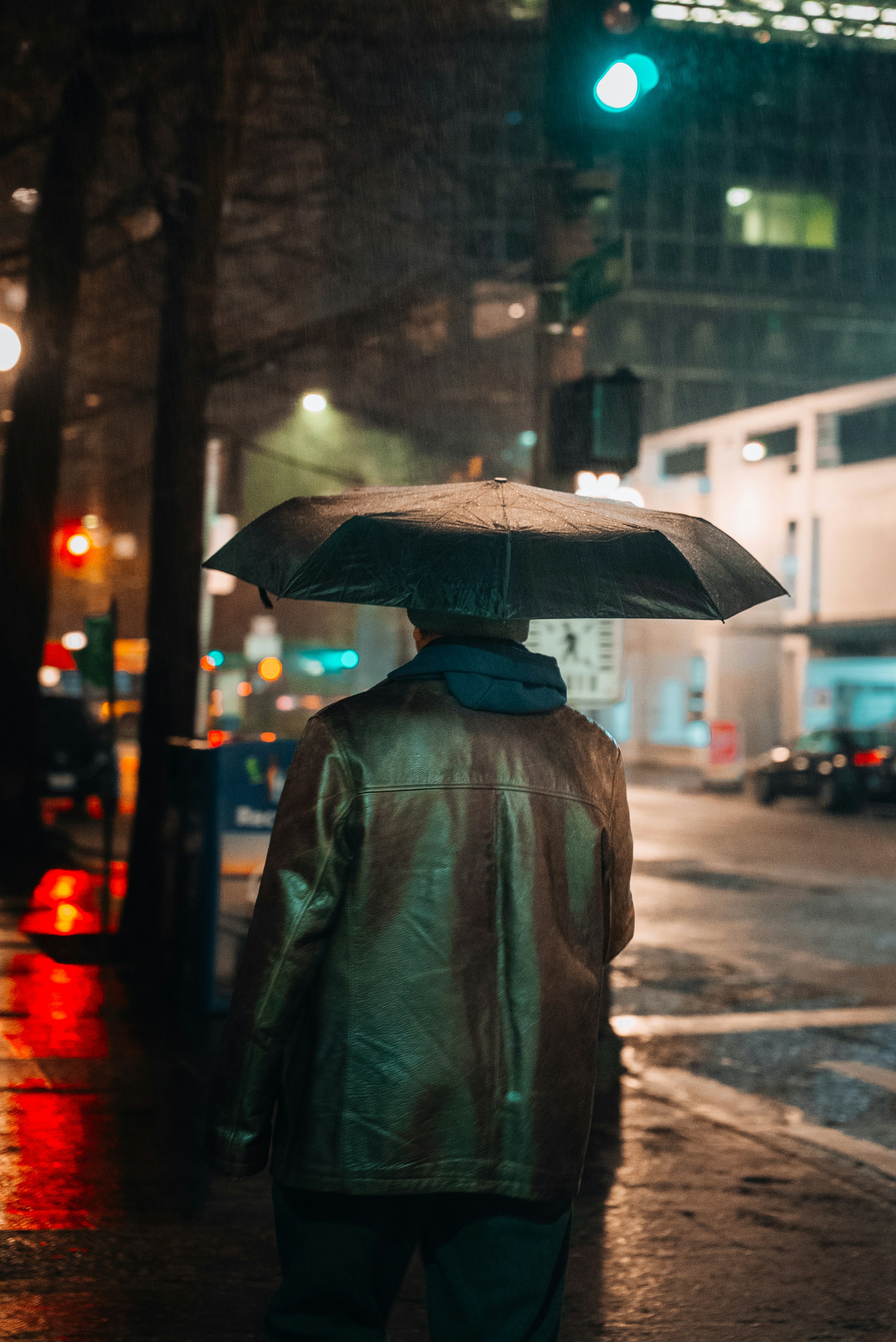 Neon Rain and a Lone Umbrella: Backturned Figure in a Rain-Slick City