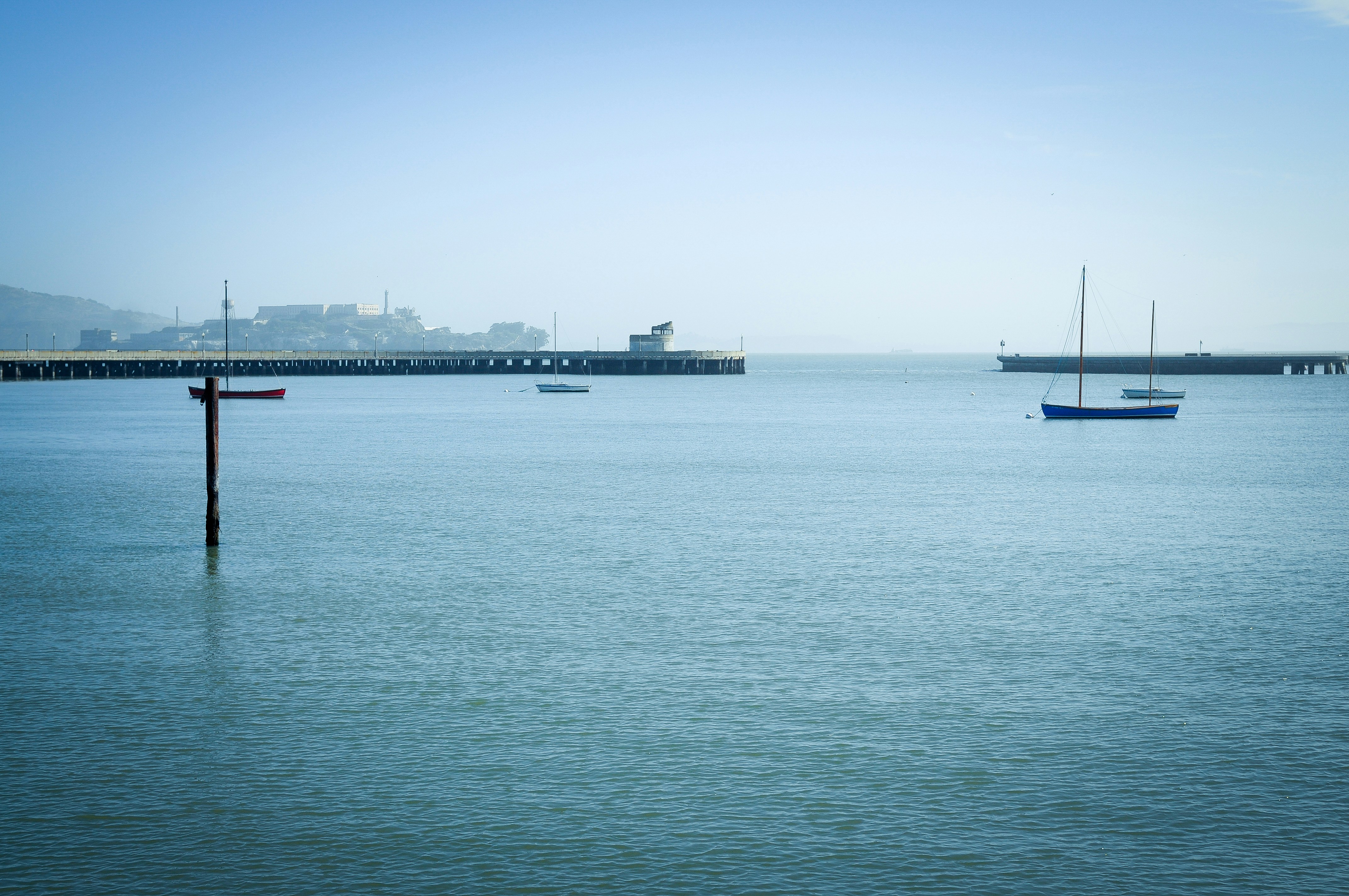 Serene Waterfront with Sailboats and Pier