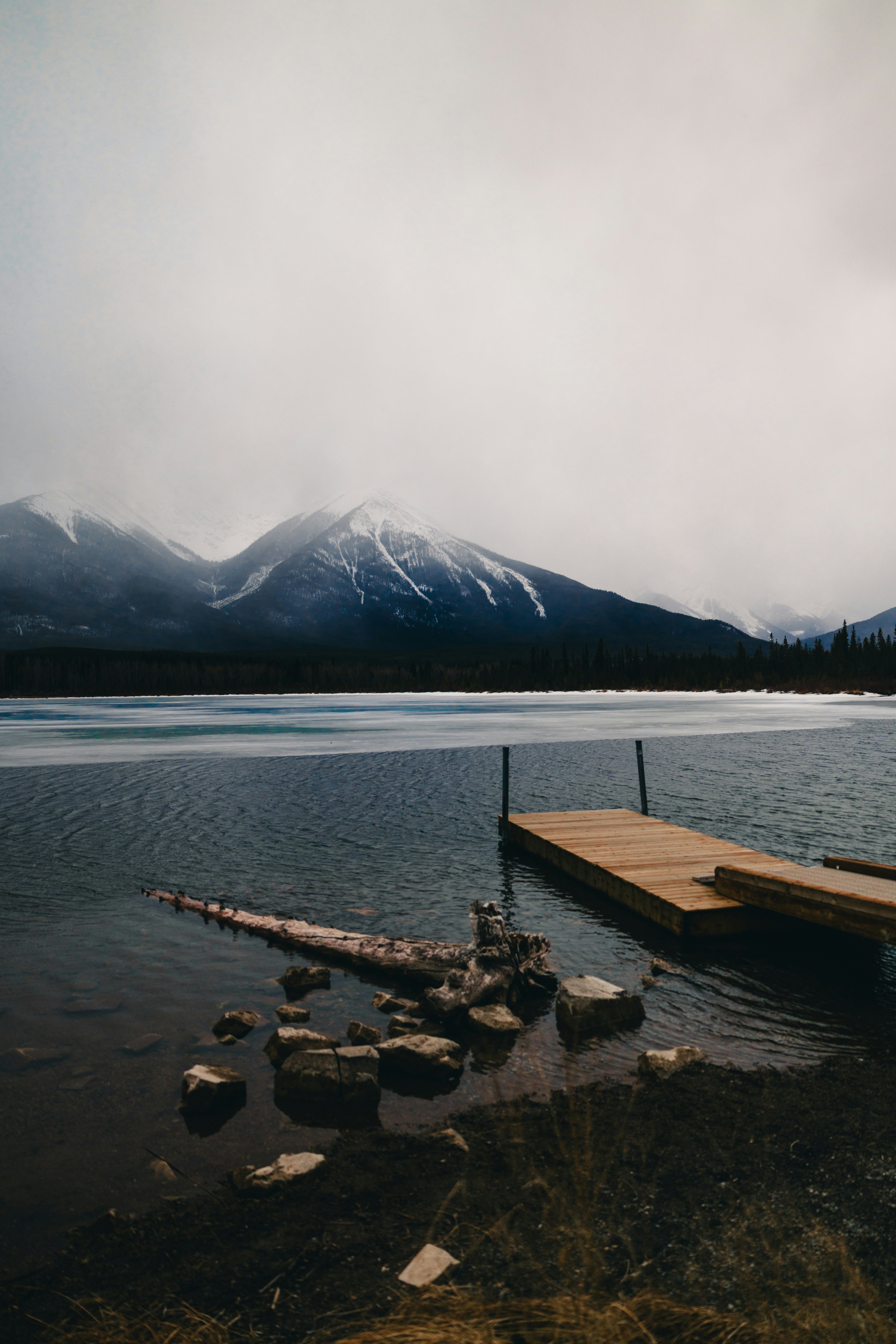 Mountains overlook a peaceful lake with a wooden dock. photo – Free ...