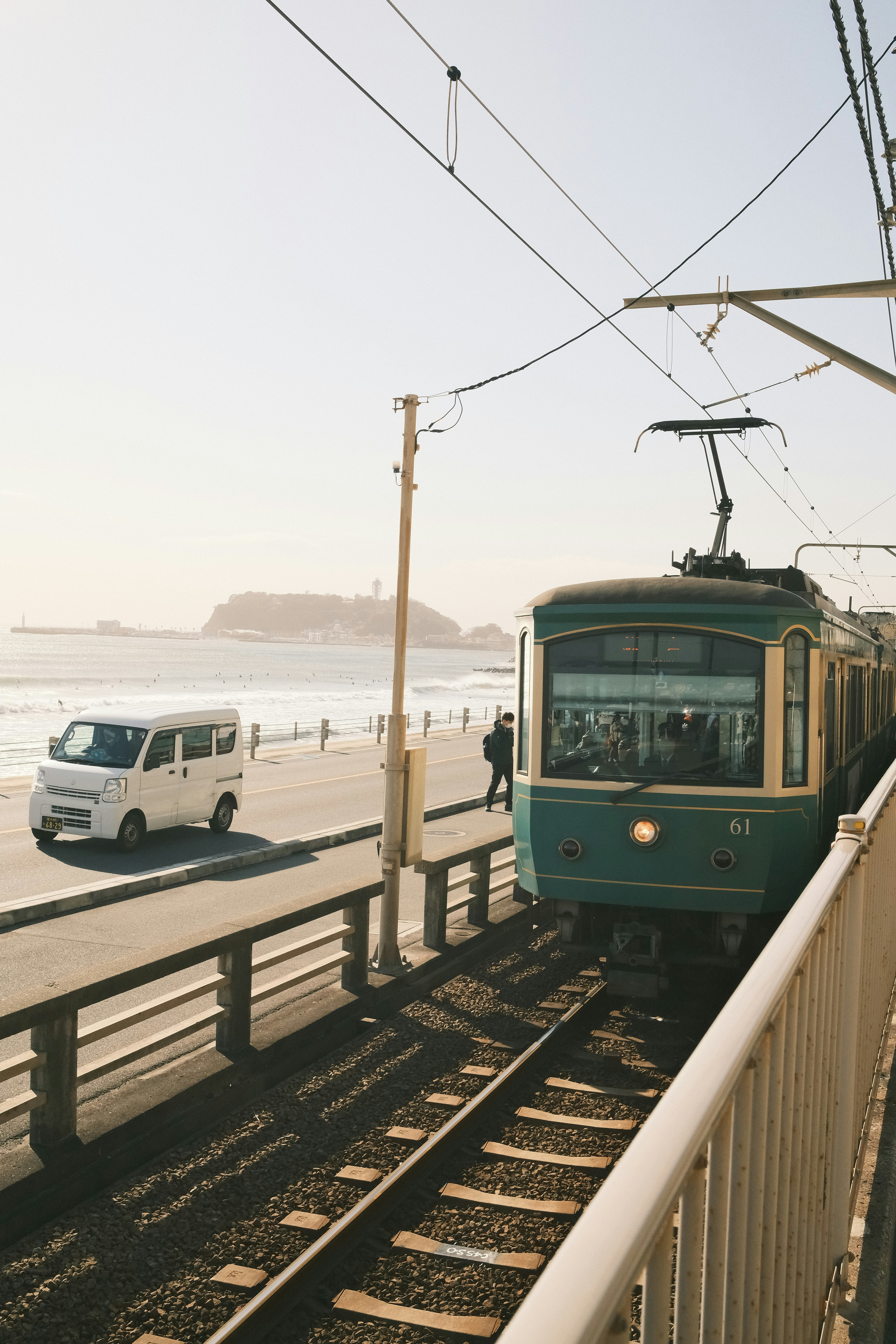 Green streetcar at the water's edge, bathed in morning light