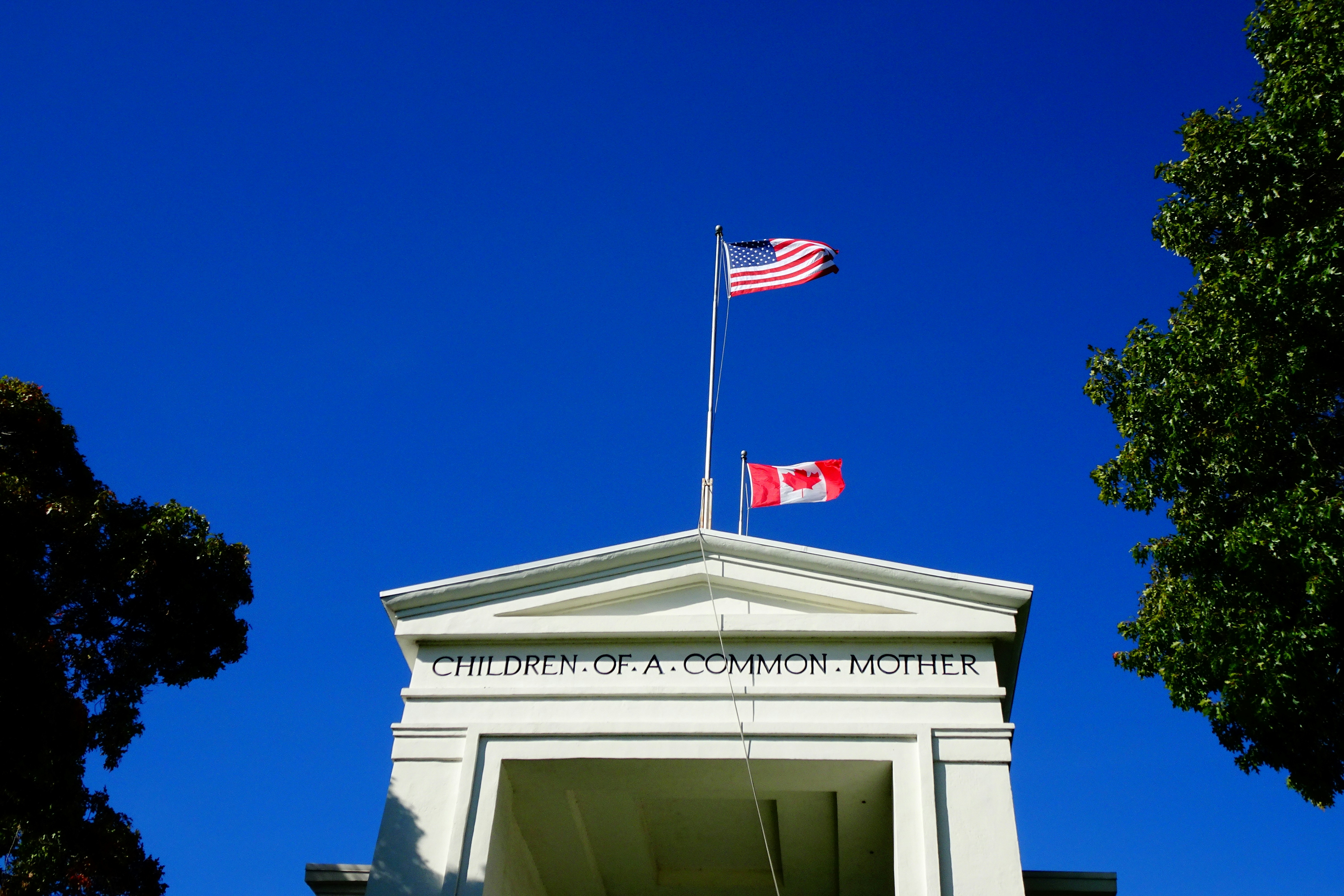 American and canadian flags fly over a border. photo – Free Canada ...