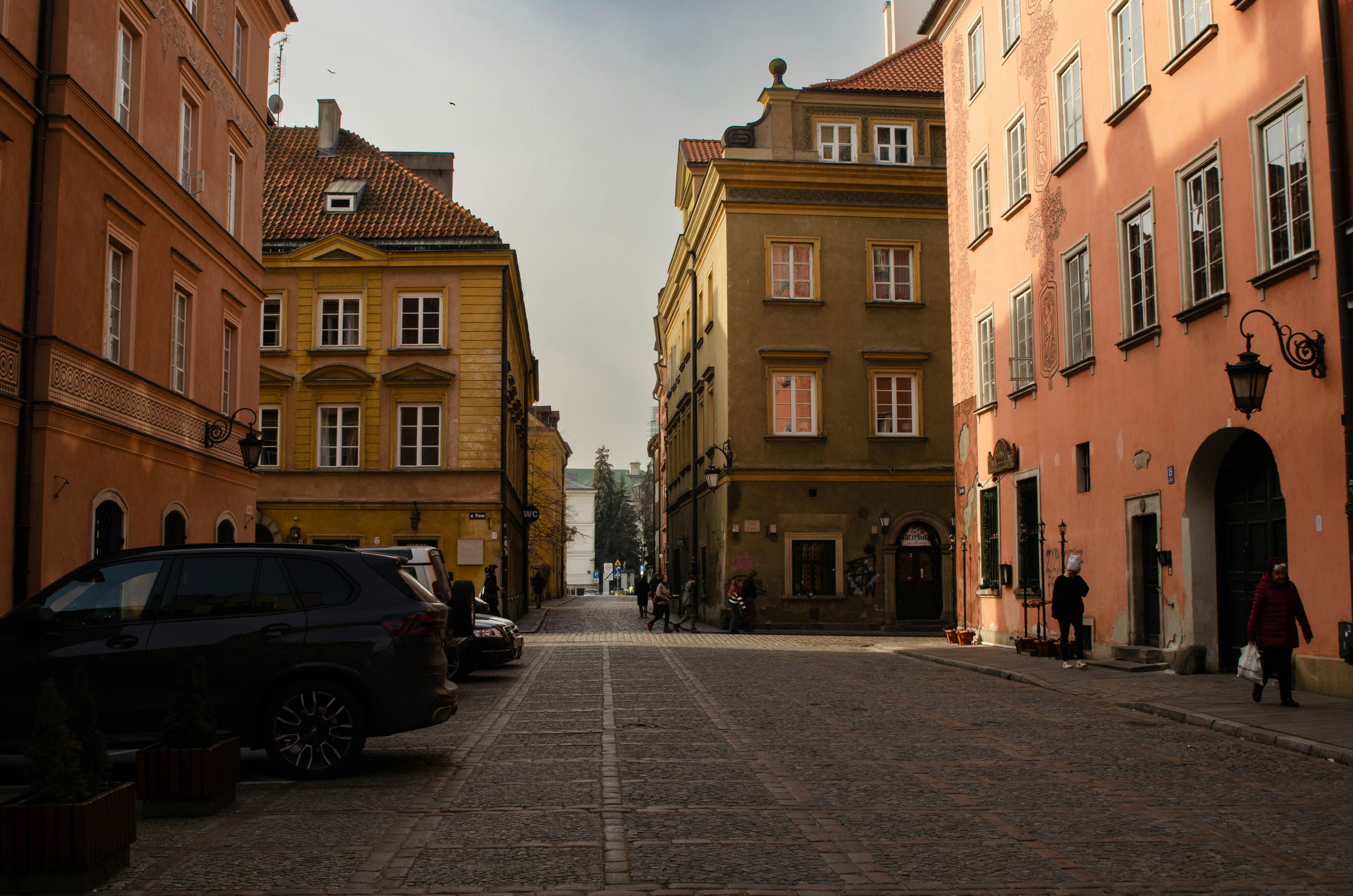 Cobblestone street flanked by colorful historic buildings under a soft, warm light.