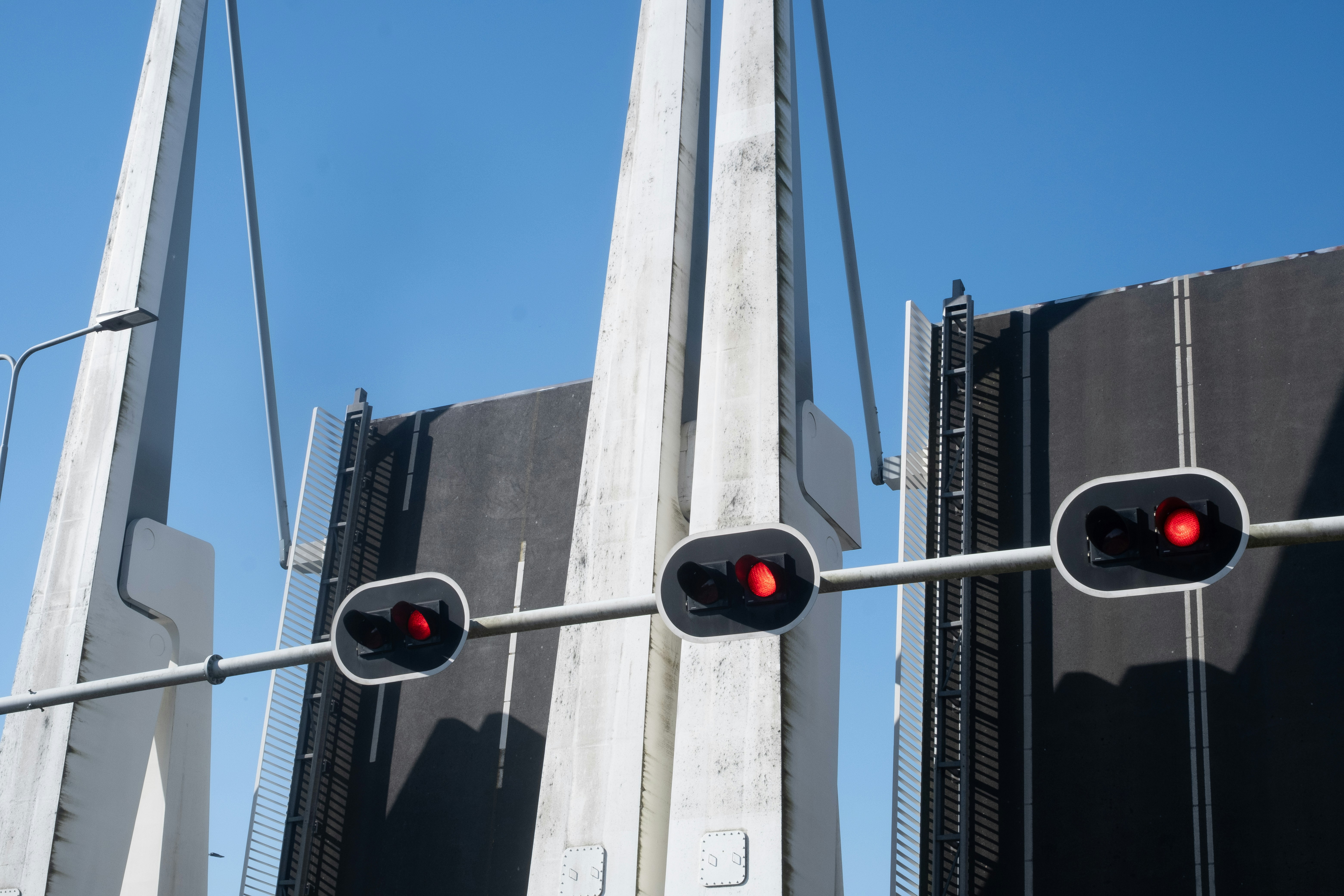 Crimson Signals Between Steel Spires Against a Bright Blue Sky