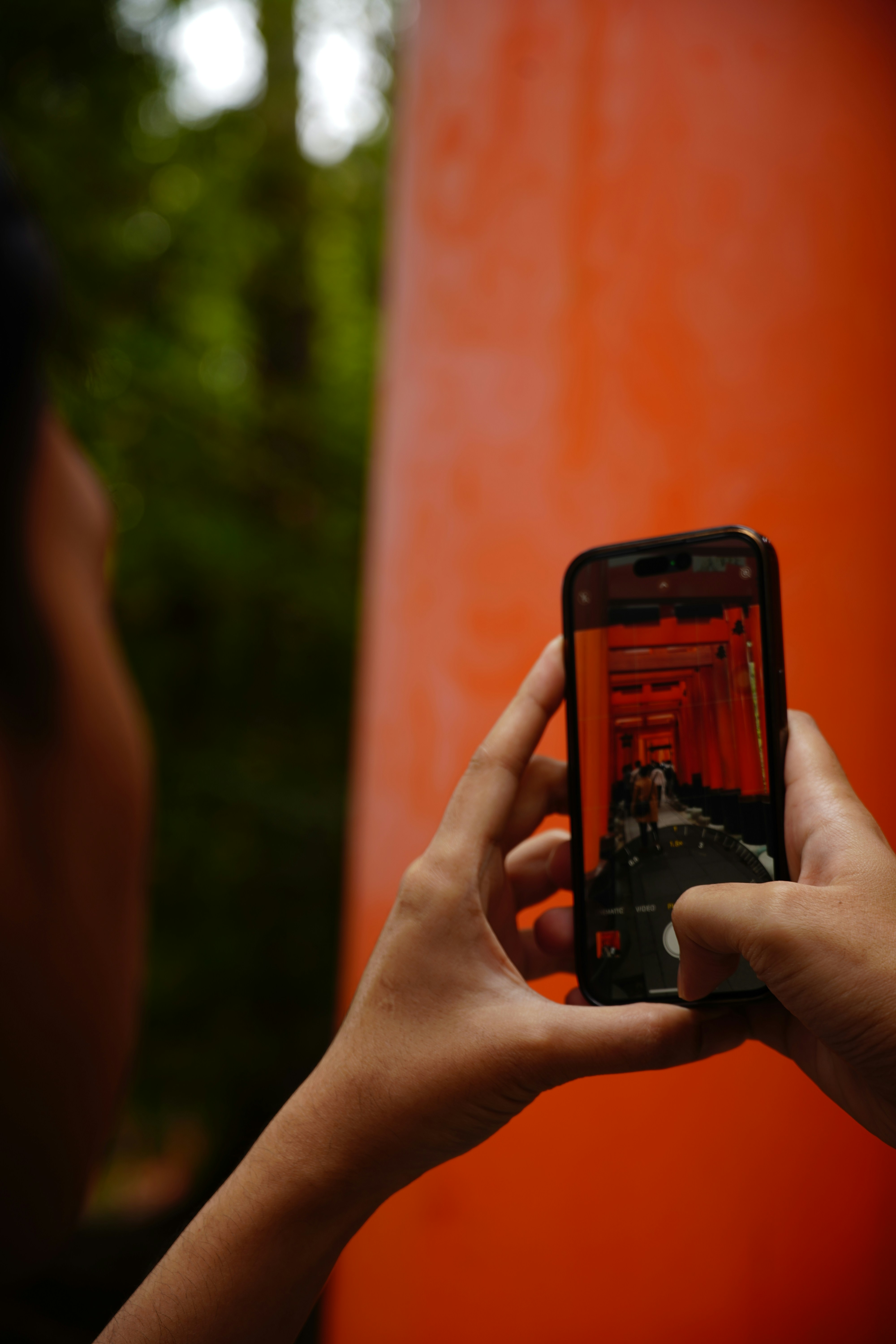 Red Torii Tunnel Framed Through a Handheld Screen
