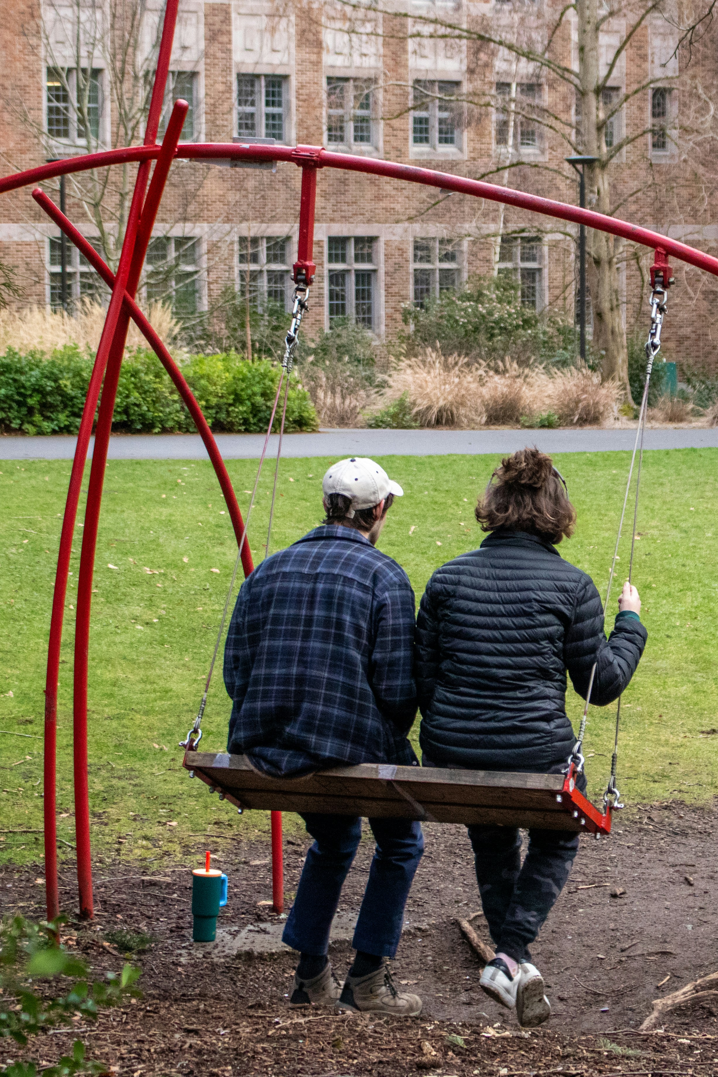 Red-Frame Swing Moment on a Brick-Campus Afternoon