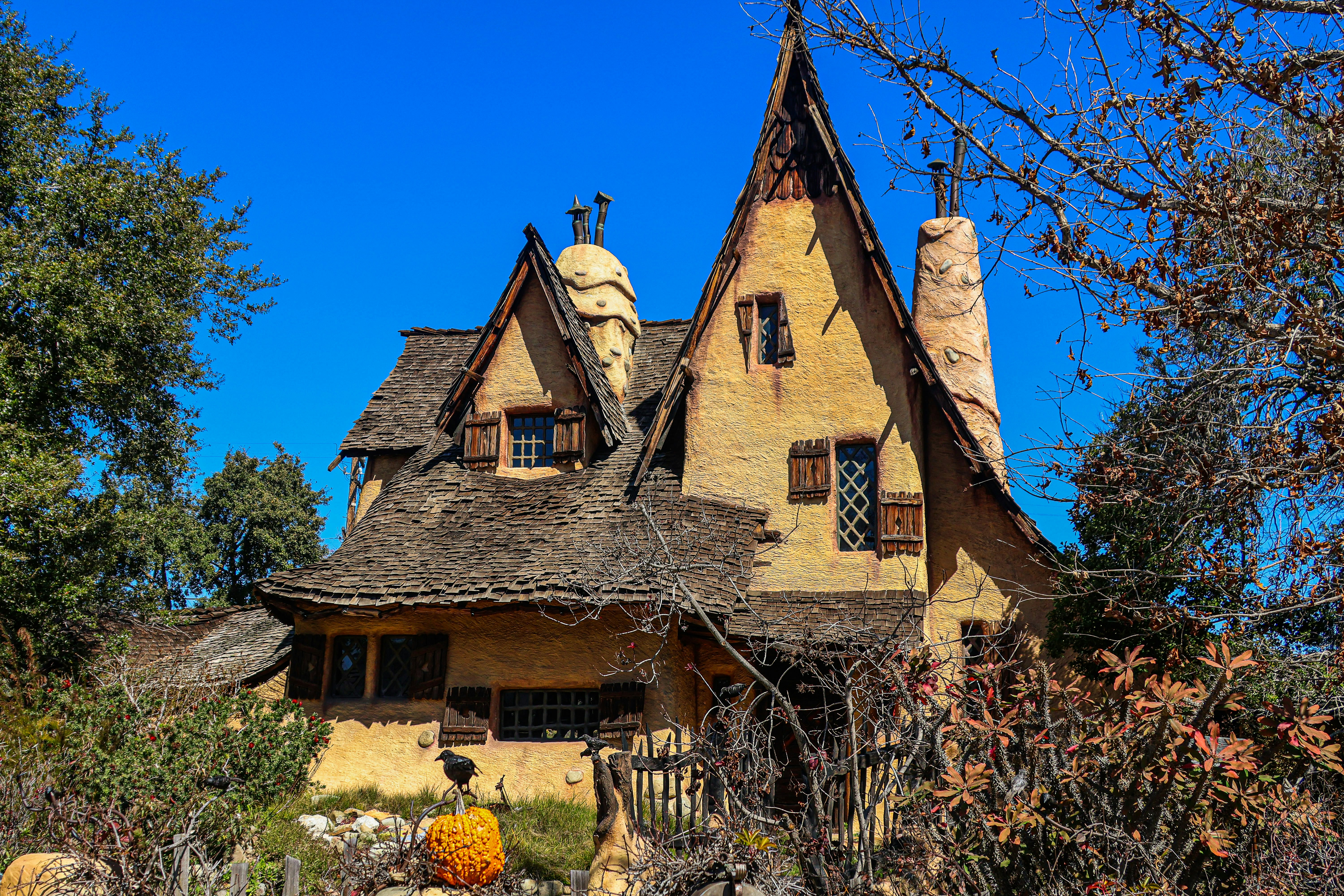 Fairytale cottage with steep gables and rustic charm under a bright blue sky.