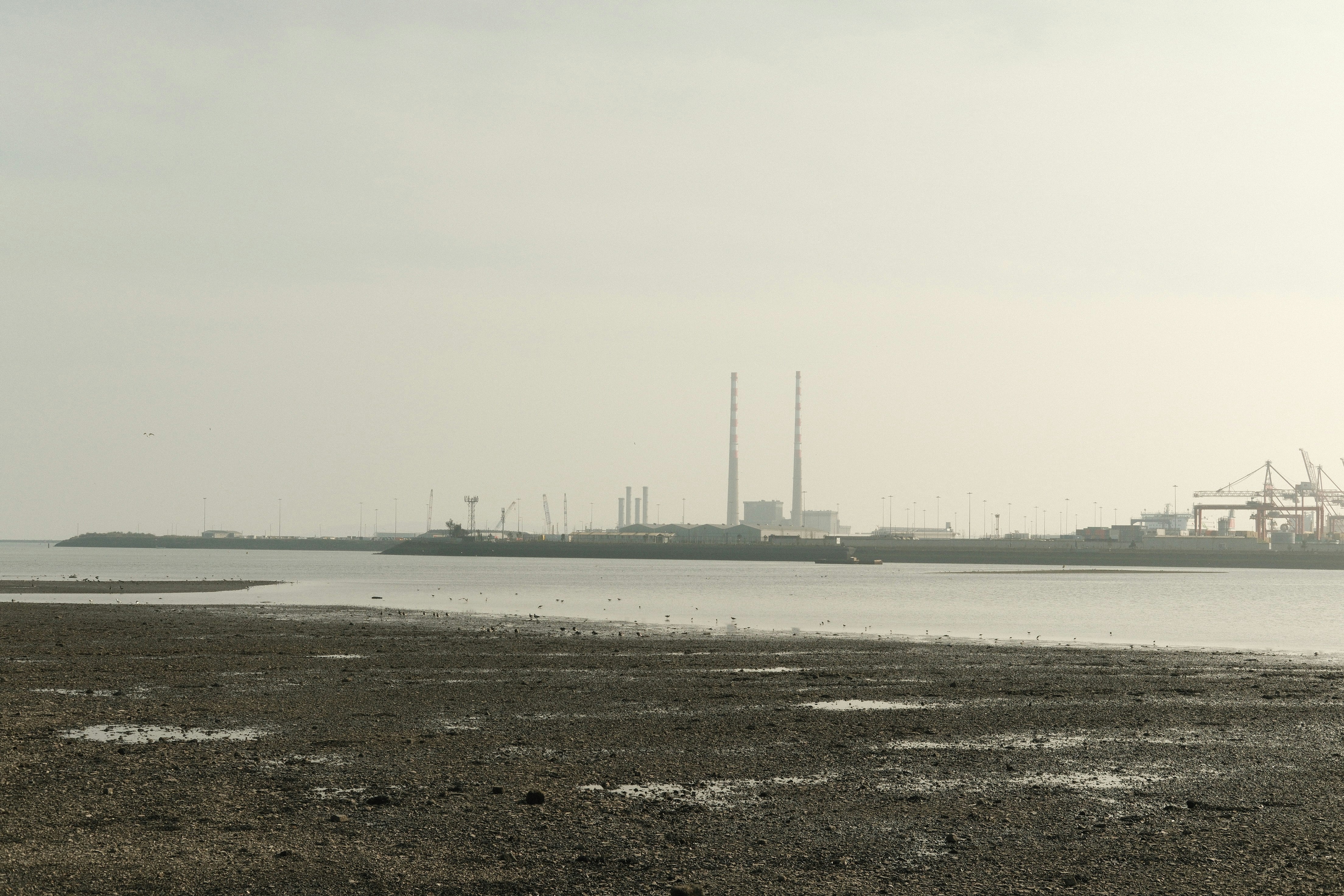 Chimneys in the Mist: Distant Industry on a Quiet Tide