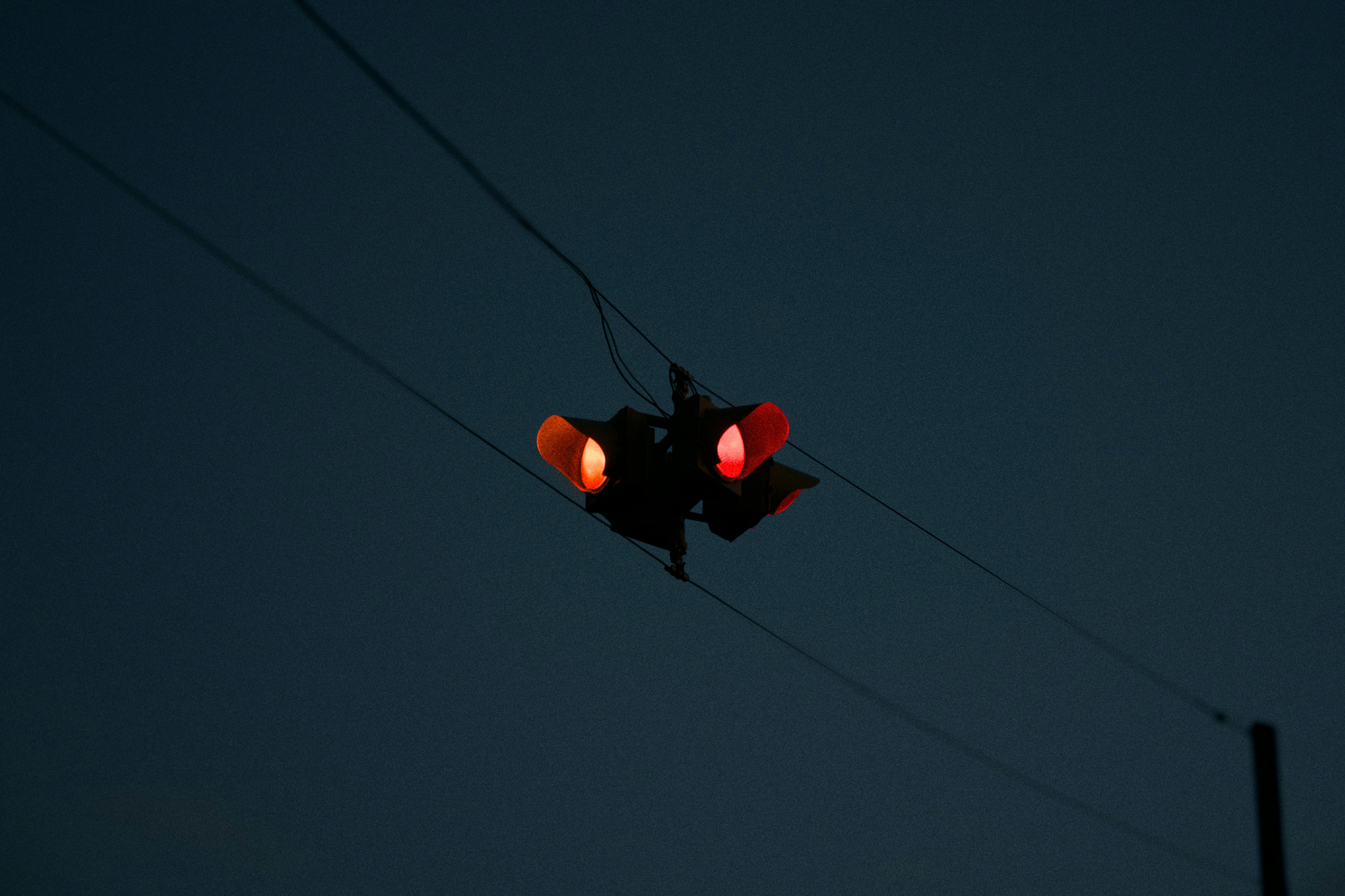 Red and orange traffic lights glow against a darkening blue sky.