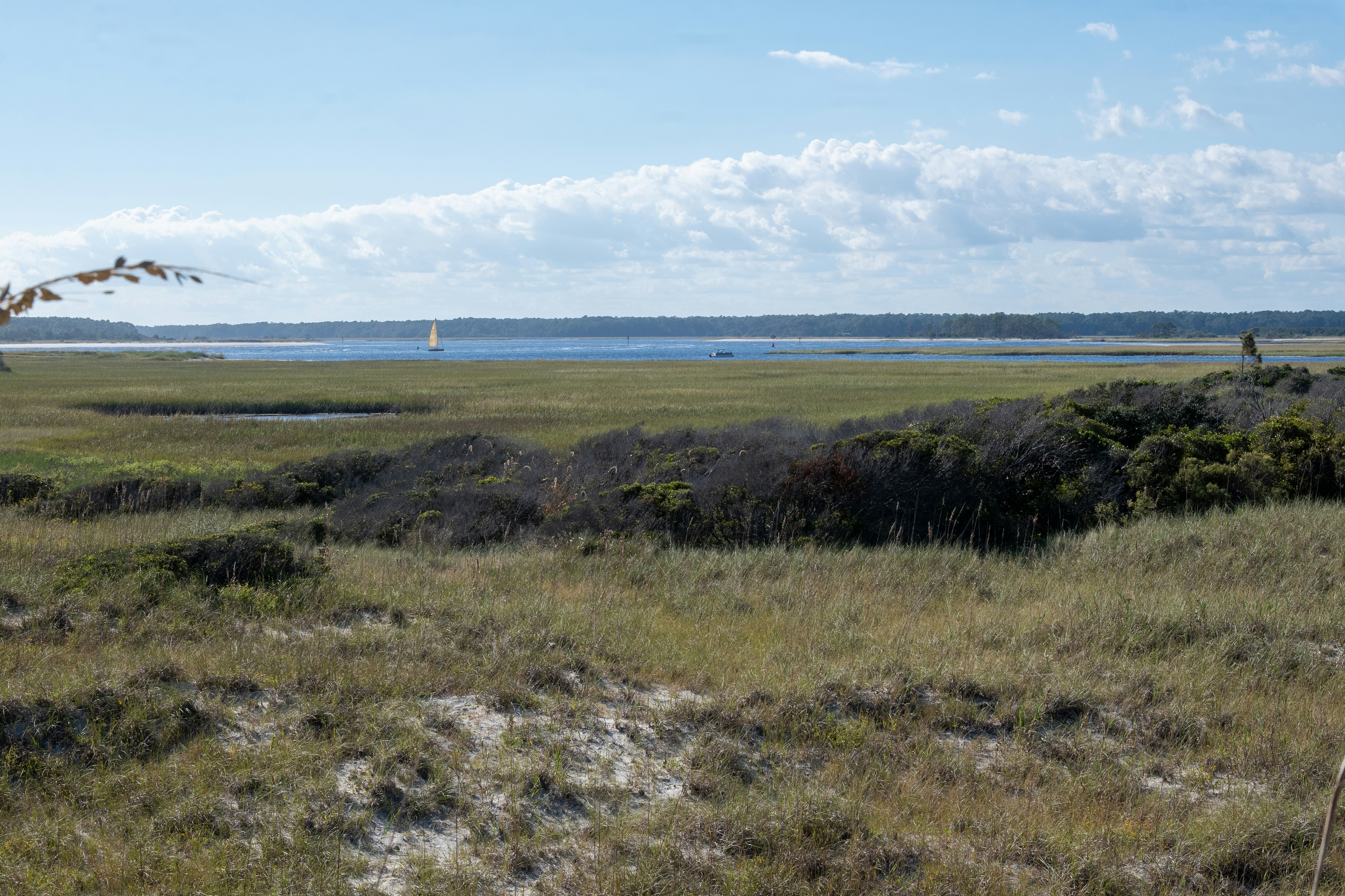 Grassy landscape overlooks a calm, blue body of water. photo – Free ...