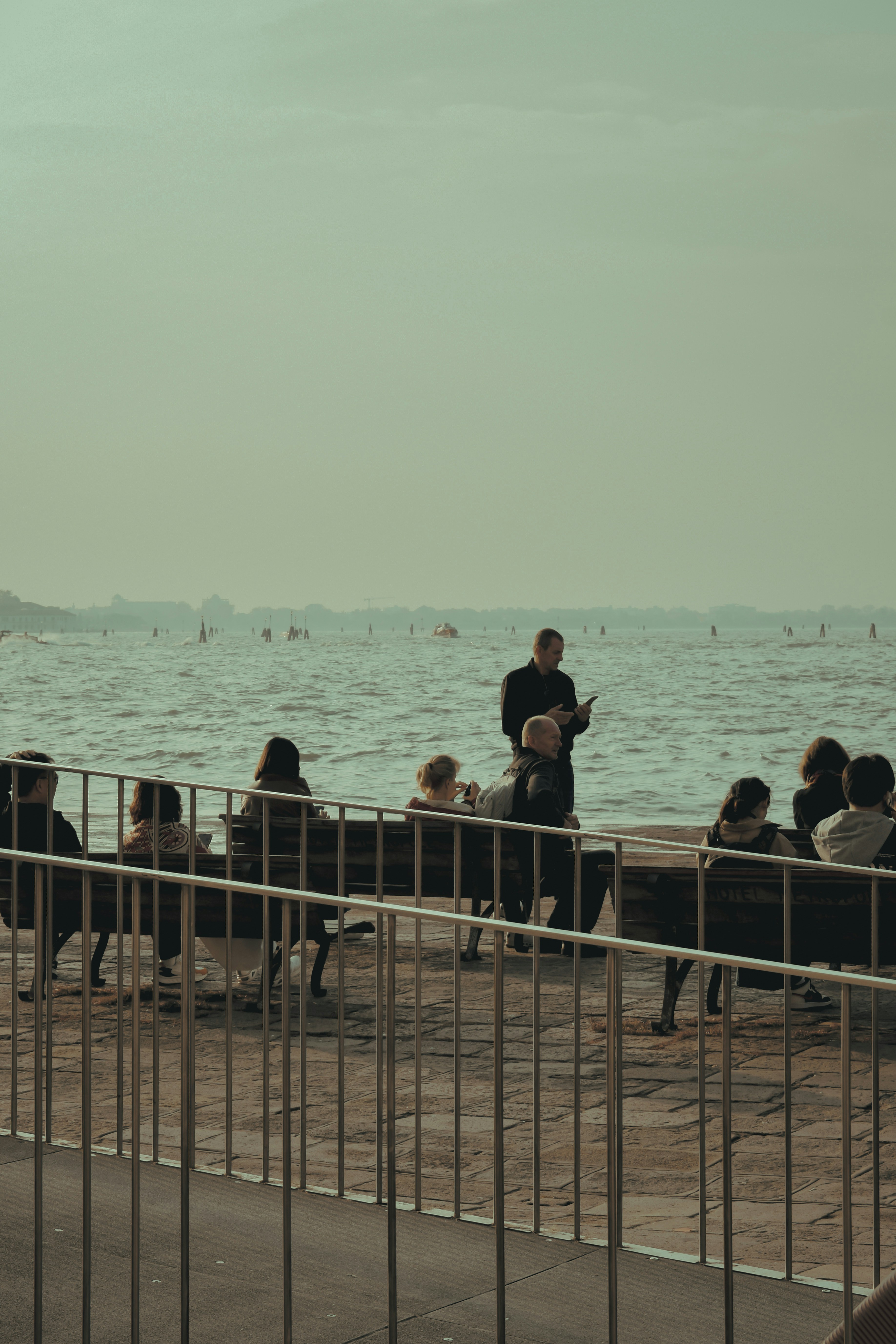 A Quiet Pause at the Seafront Railings