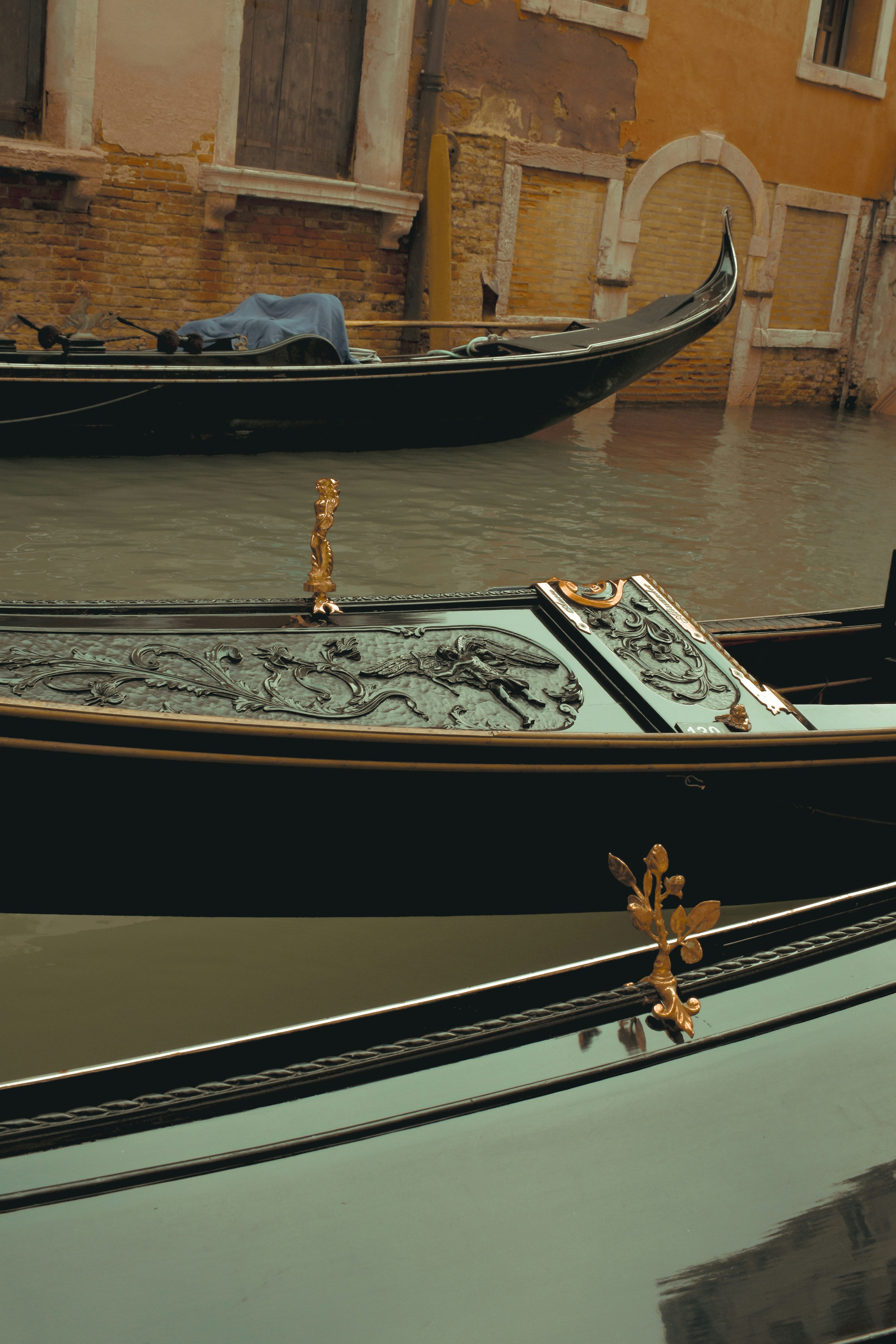 Gilded Crest on Venice's Quiet Canal: A Close-Up of Ornate Gondola Details