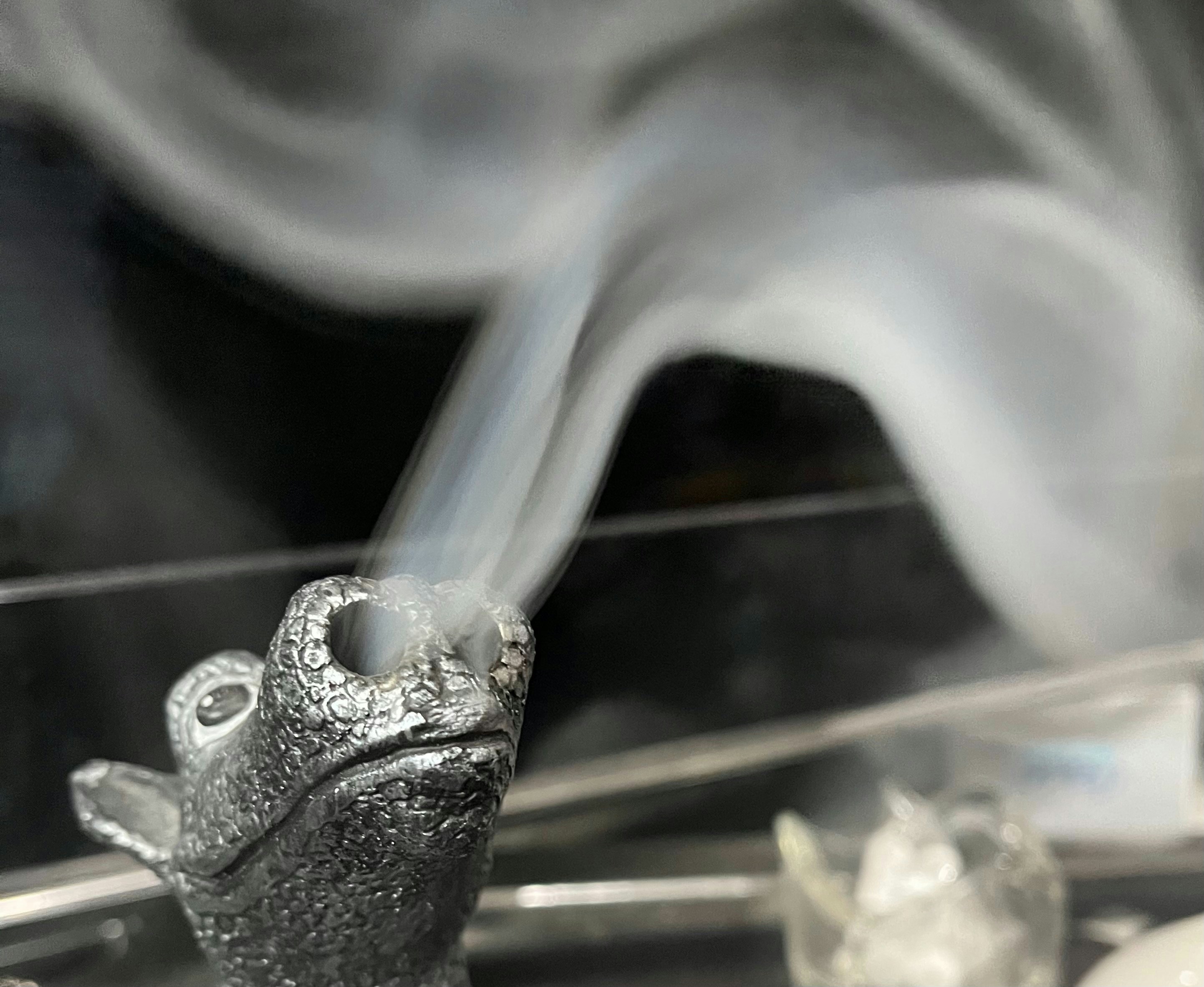 Dragon figurine exhales smoke from its nostrils.