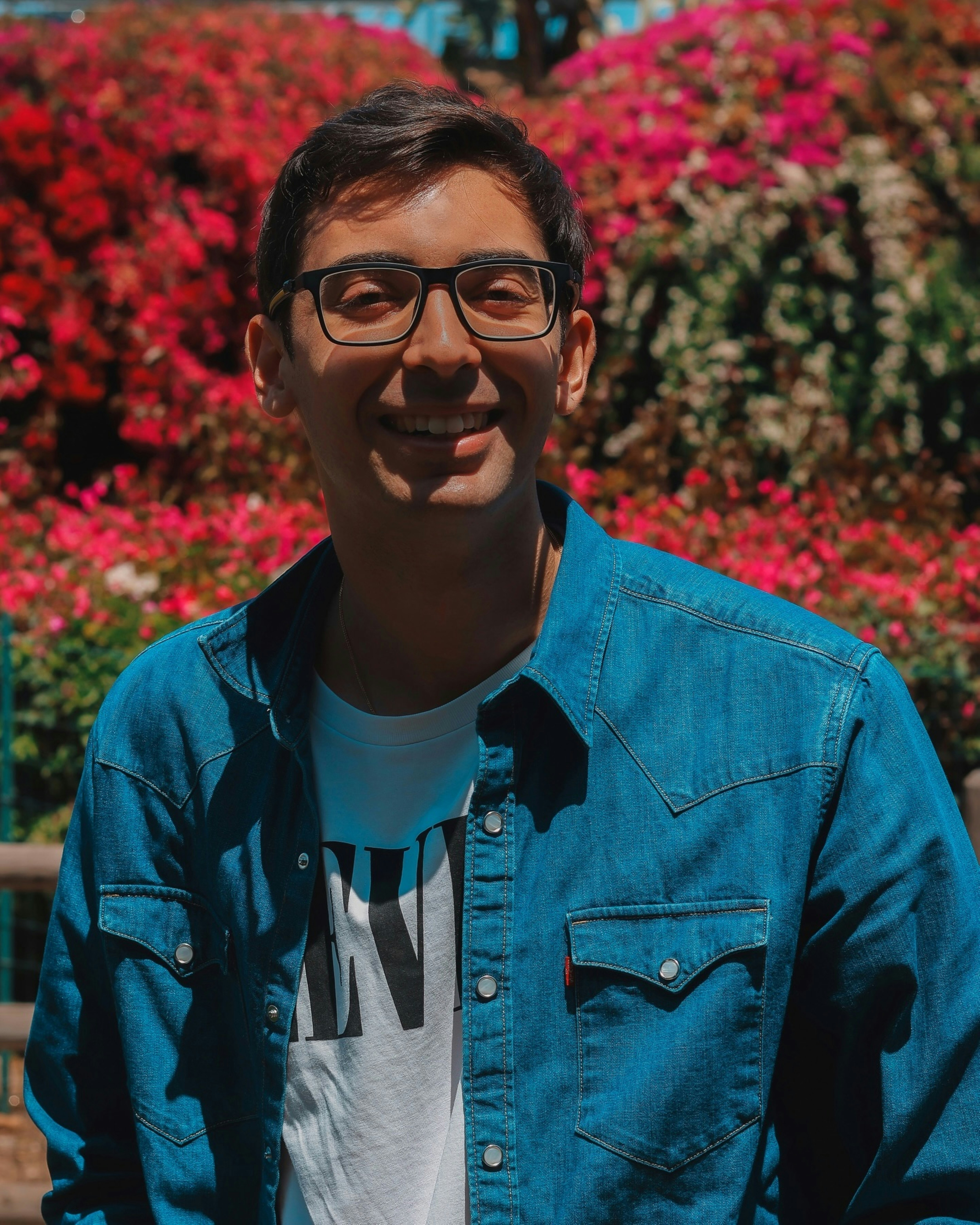 A smiling man poses in front of blossoms. photo – Free Portrait Image ...