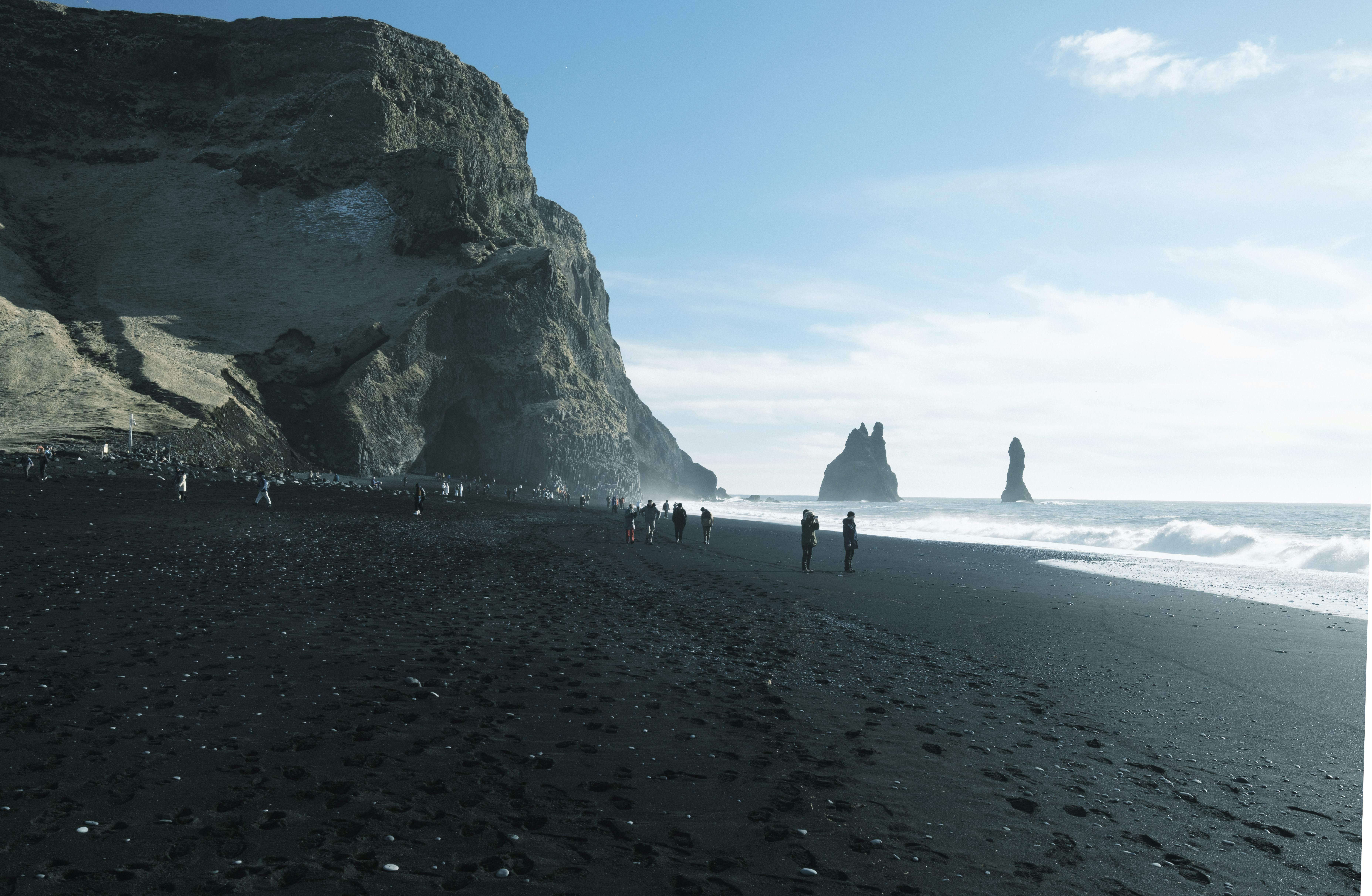 A black sand beach with cliffs and rock formations. photo – Free Beach ...