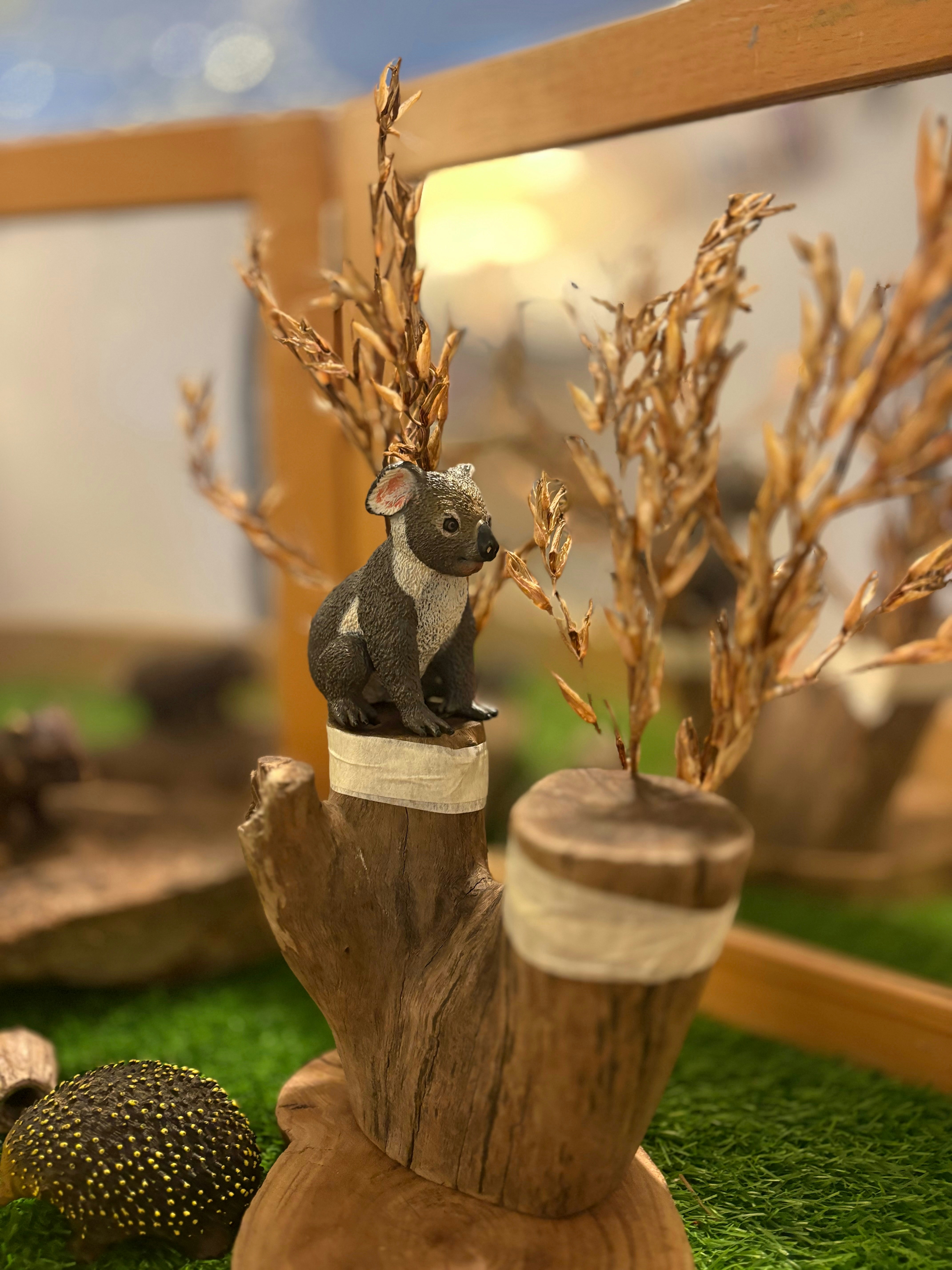 La figurine de koala est posée au sommet d’un élément décoratif en bois ...