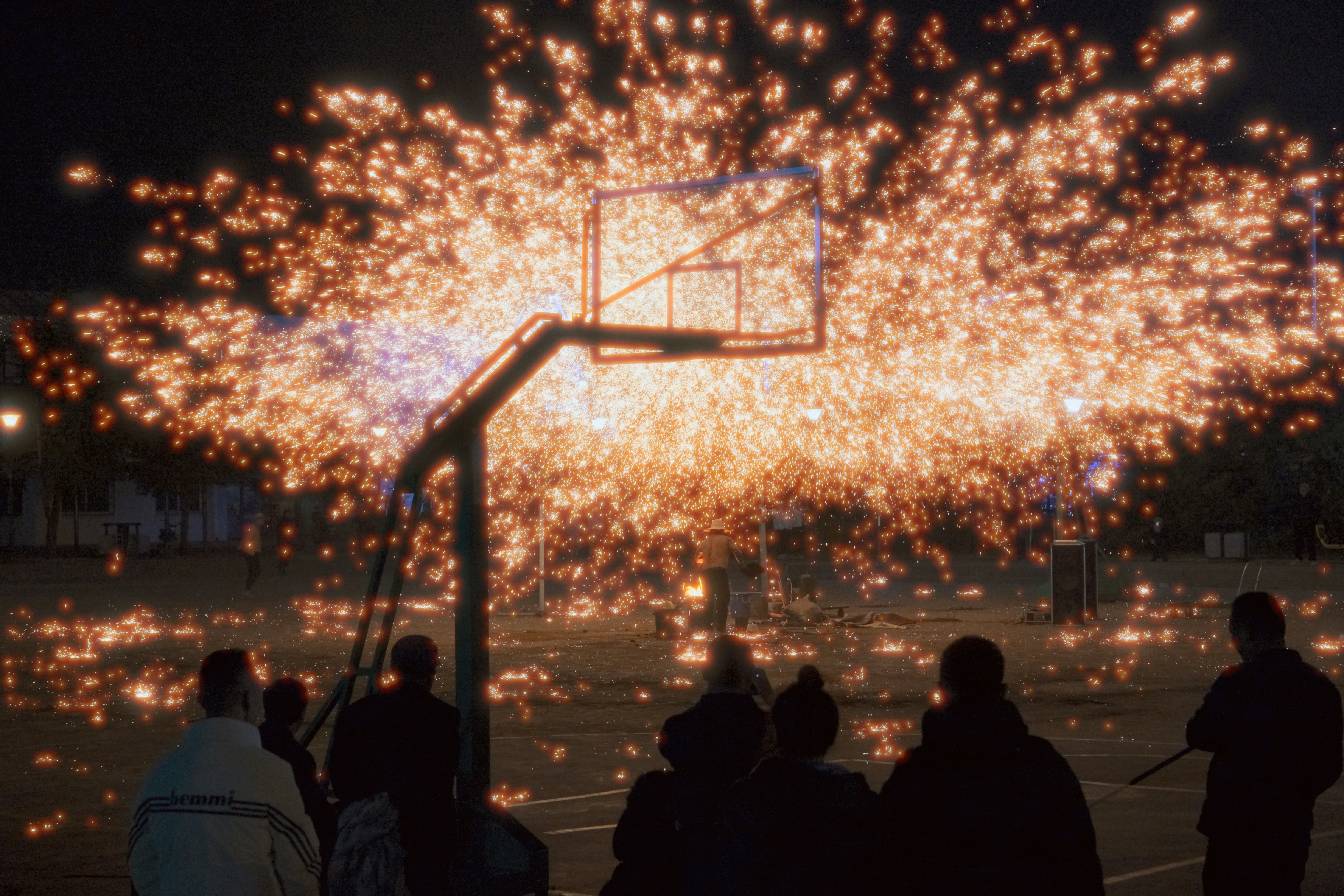 Fireworks explode behind a basketball hoop at night. photo – Free Man ...