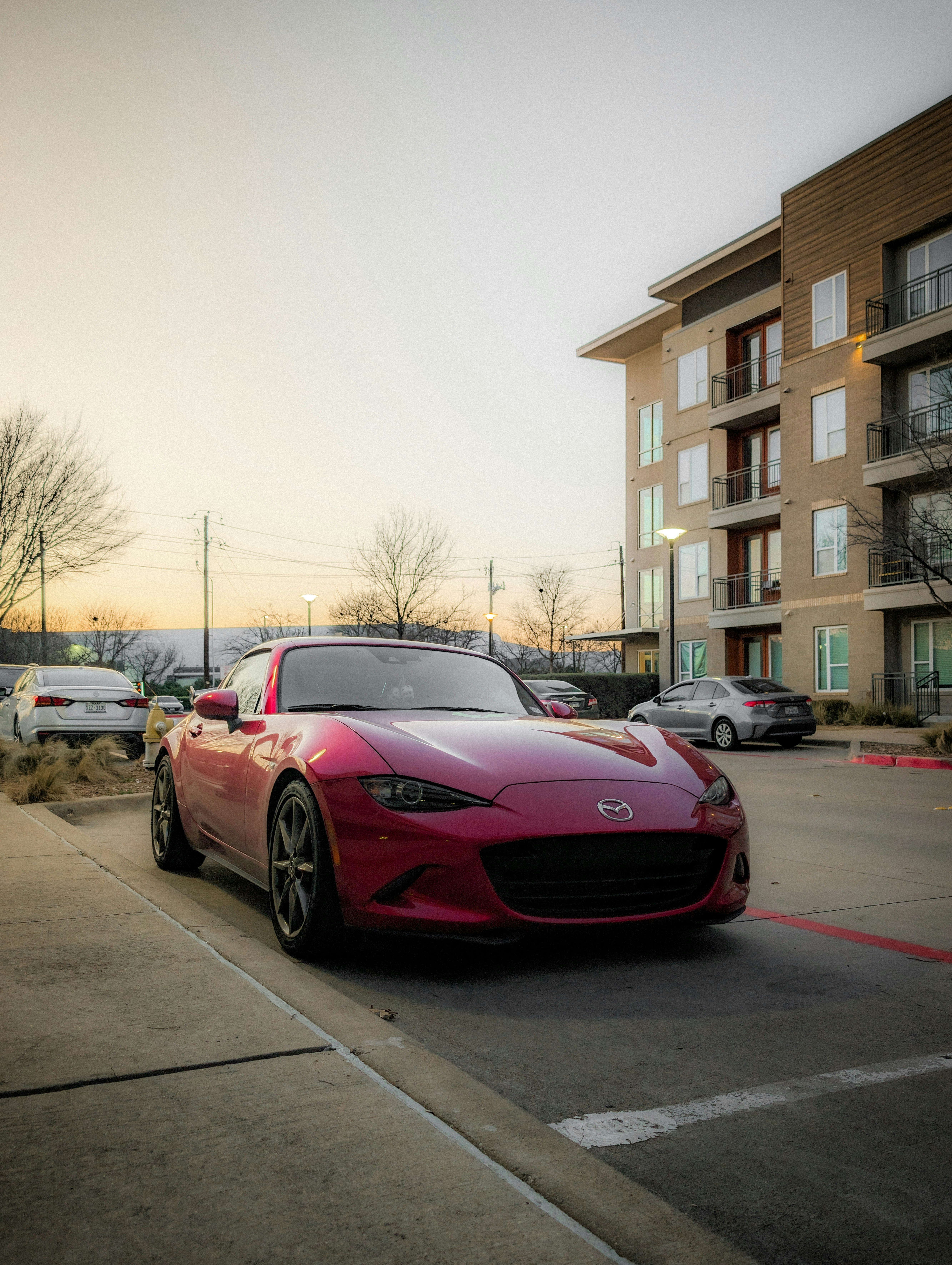 A red mazda miata parked near an apartment. photo – Free Car Image on ...