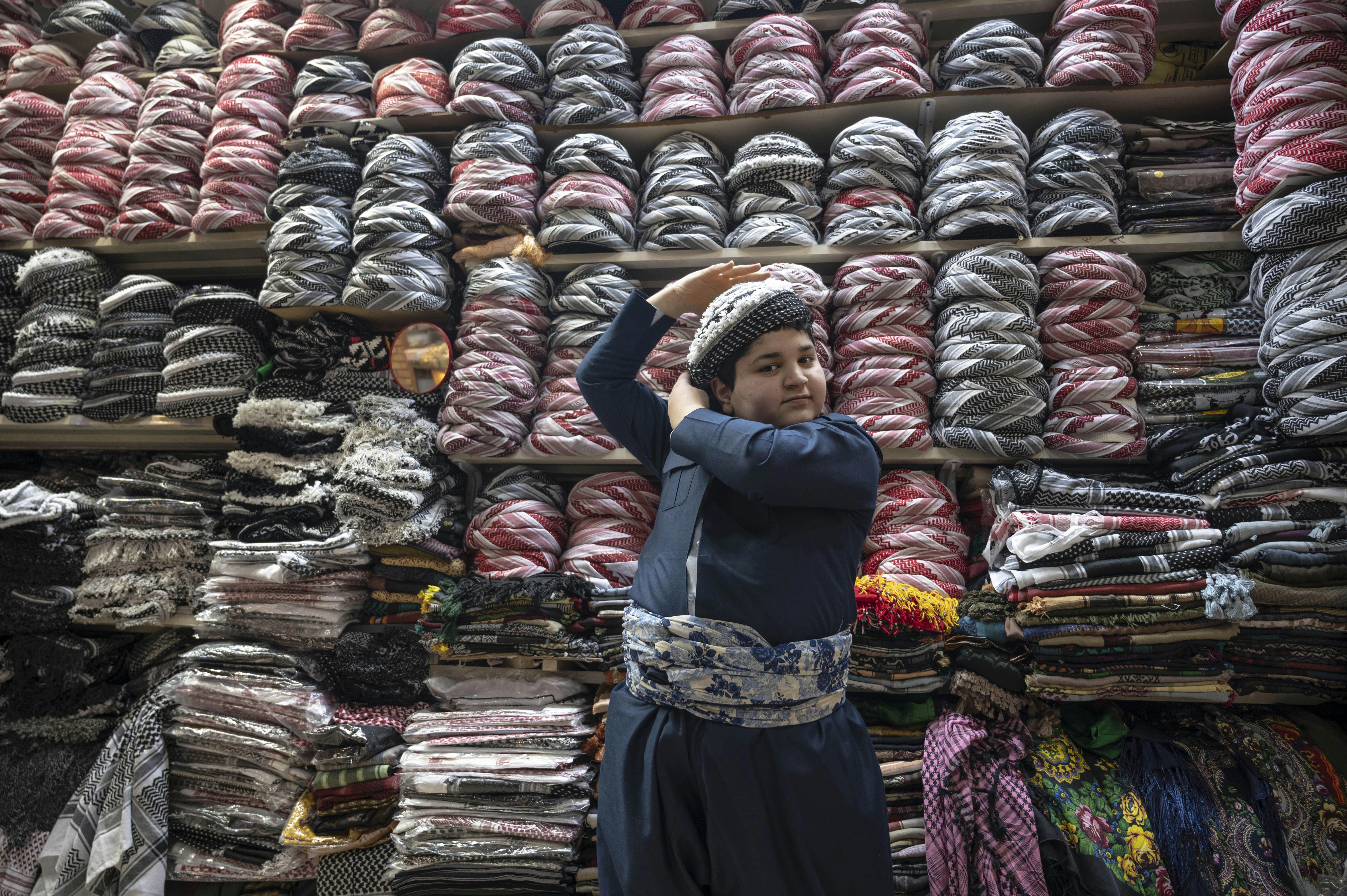 A boy holds up a hat in a shop. photo – Free Woman Image on Unsplash