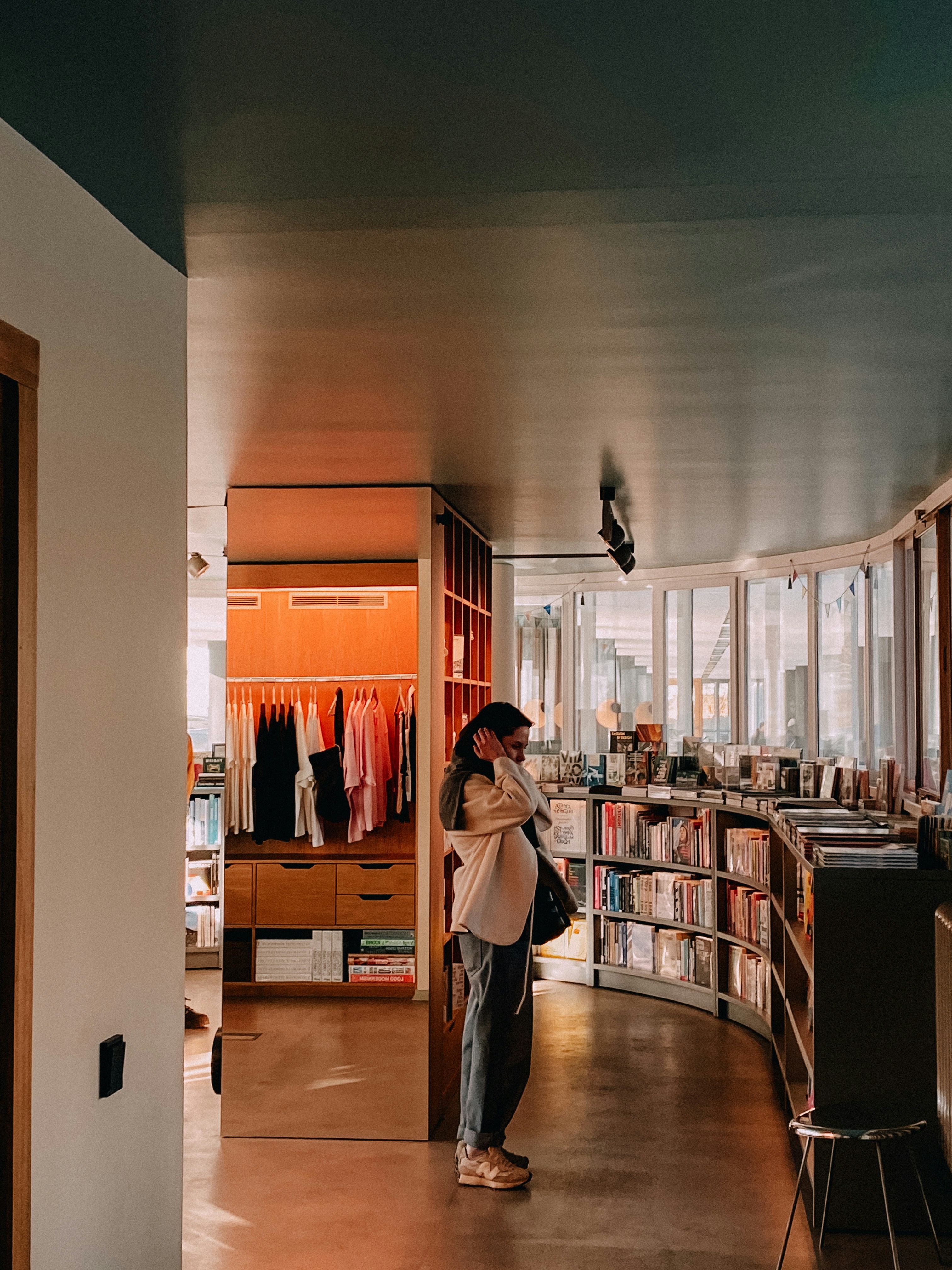 Person browses books in a well-lit library. photo – Free Man Image on ...