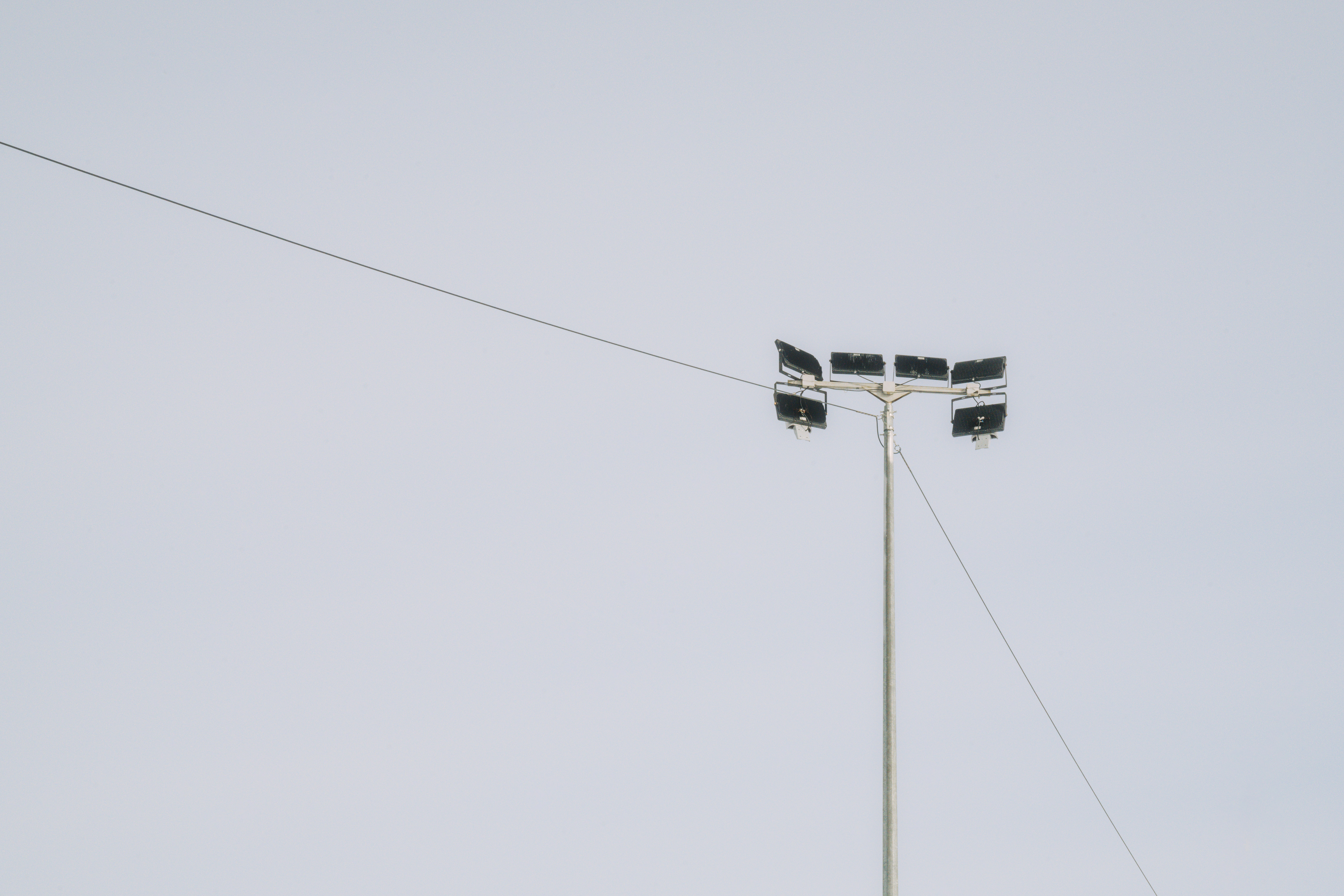 Photo taken with Sony ILCE-7RM4A, lens Samyang 24-70mm, More beautiful photos: https://t.me/+XOwdYHUkFq83YmYy | Stadium lights illuminate a gray, overcast sky.