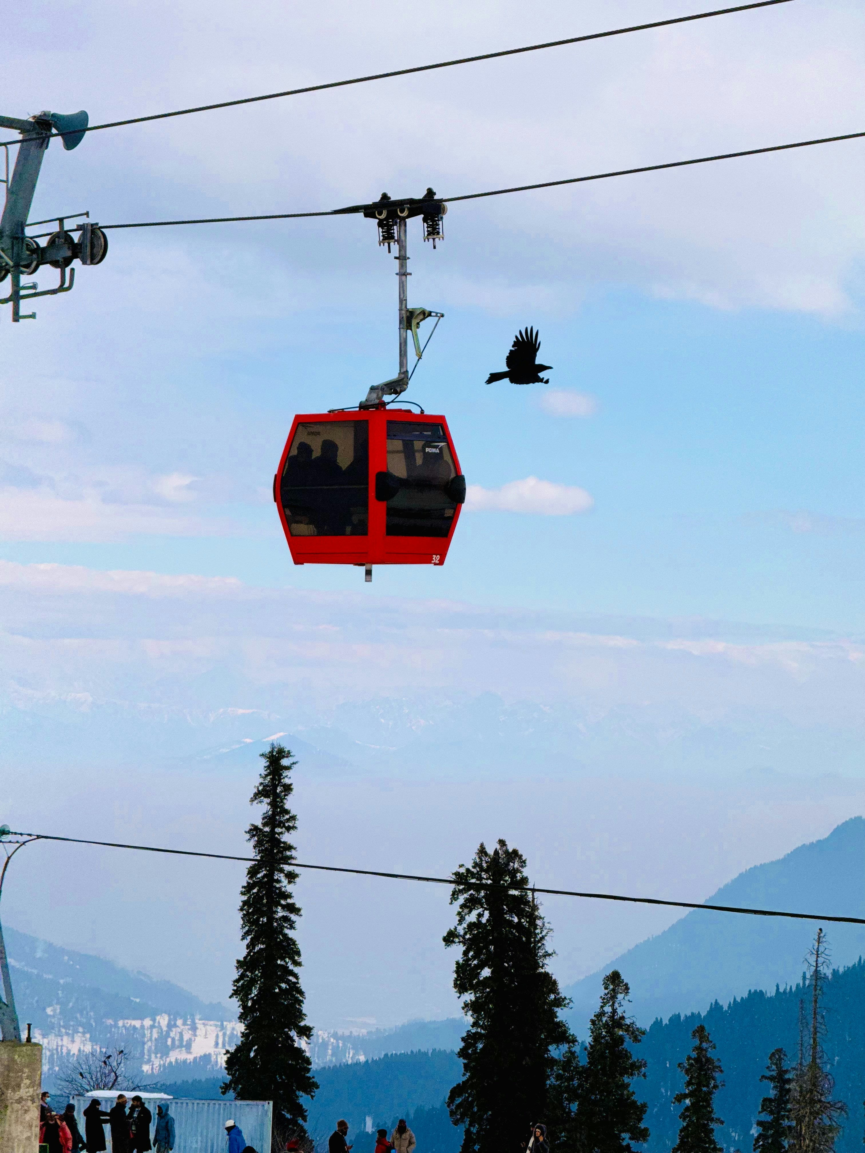 A red cable car ascends over a mountain landscape. photo – Free Gulmarg ...