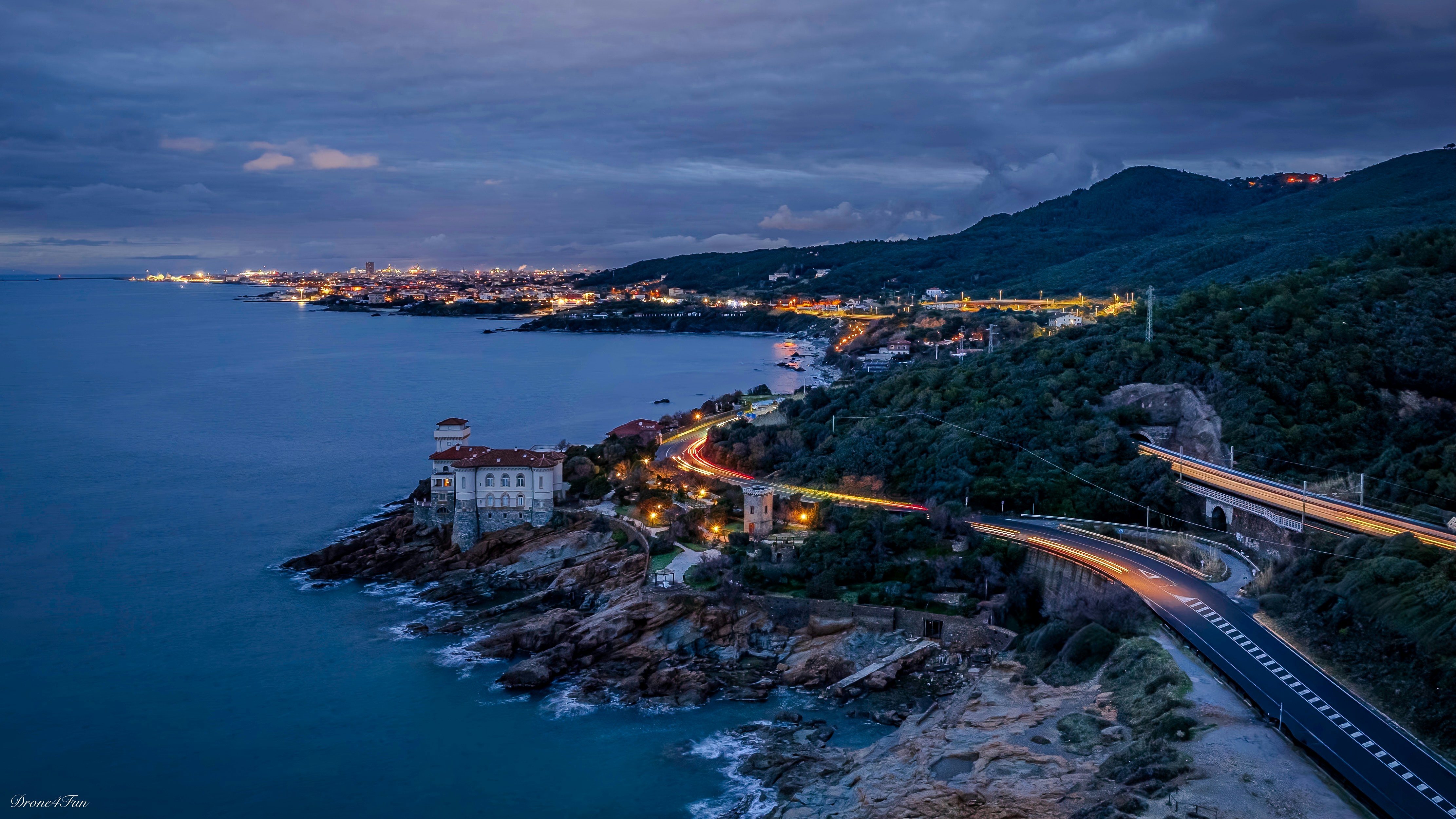 Coastal city lights up at dusk.