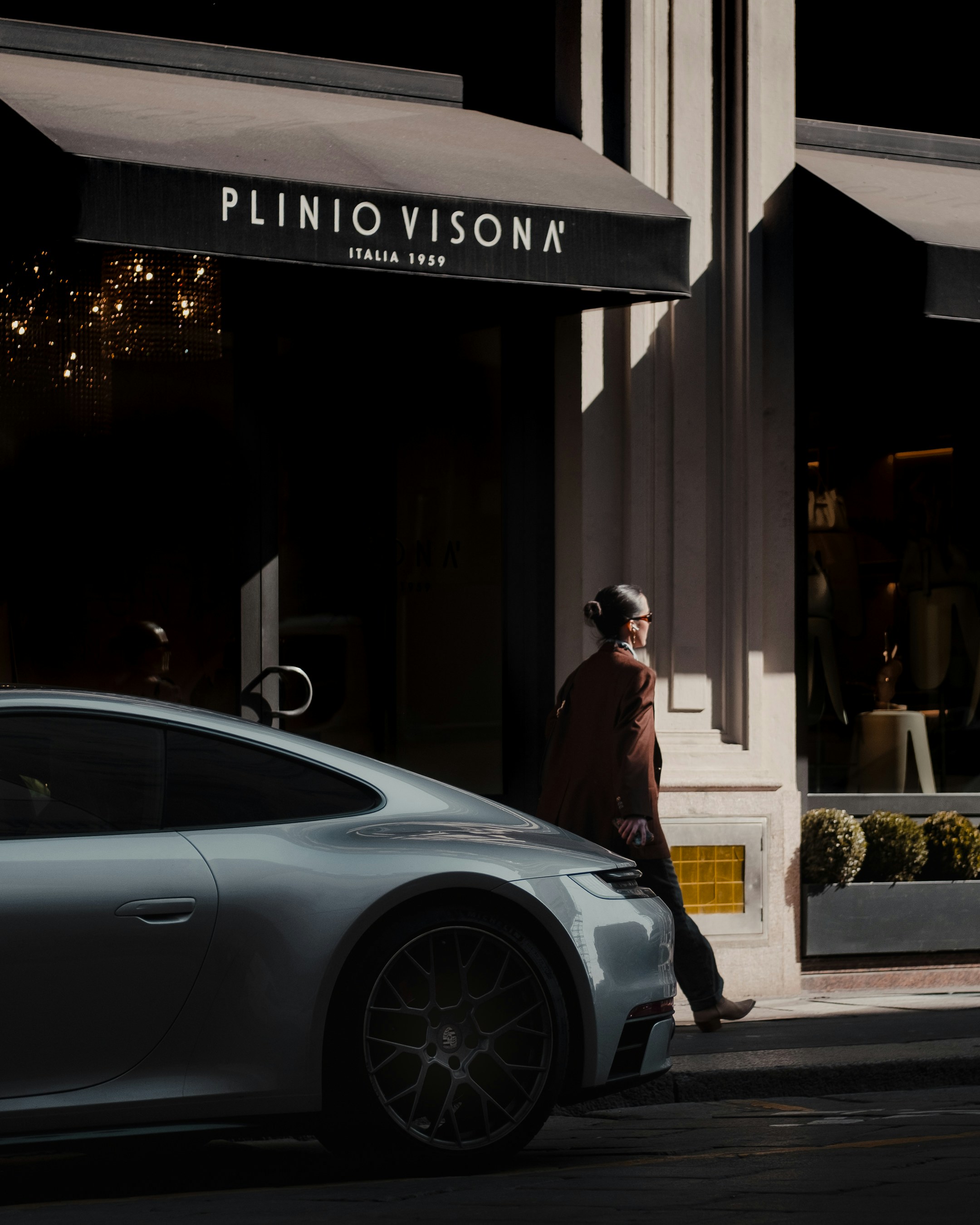 Woman leaning against a building with a luxury car. photo – Free Car ...