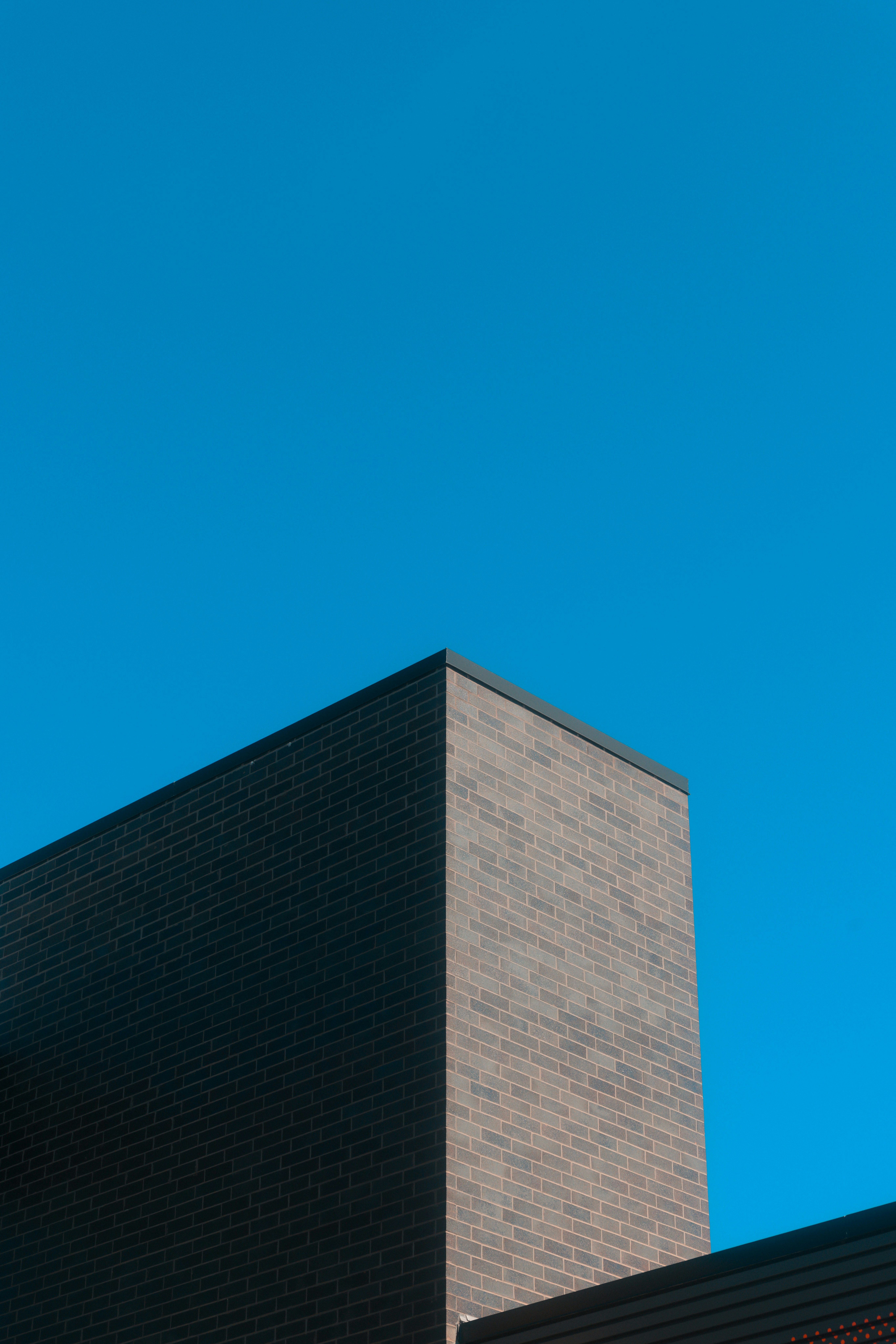Building corner contrasts with the bright blue sky. photo – Free ...