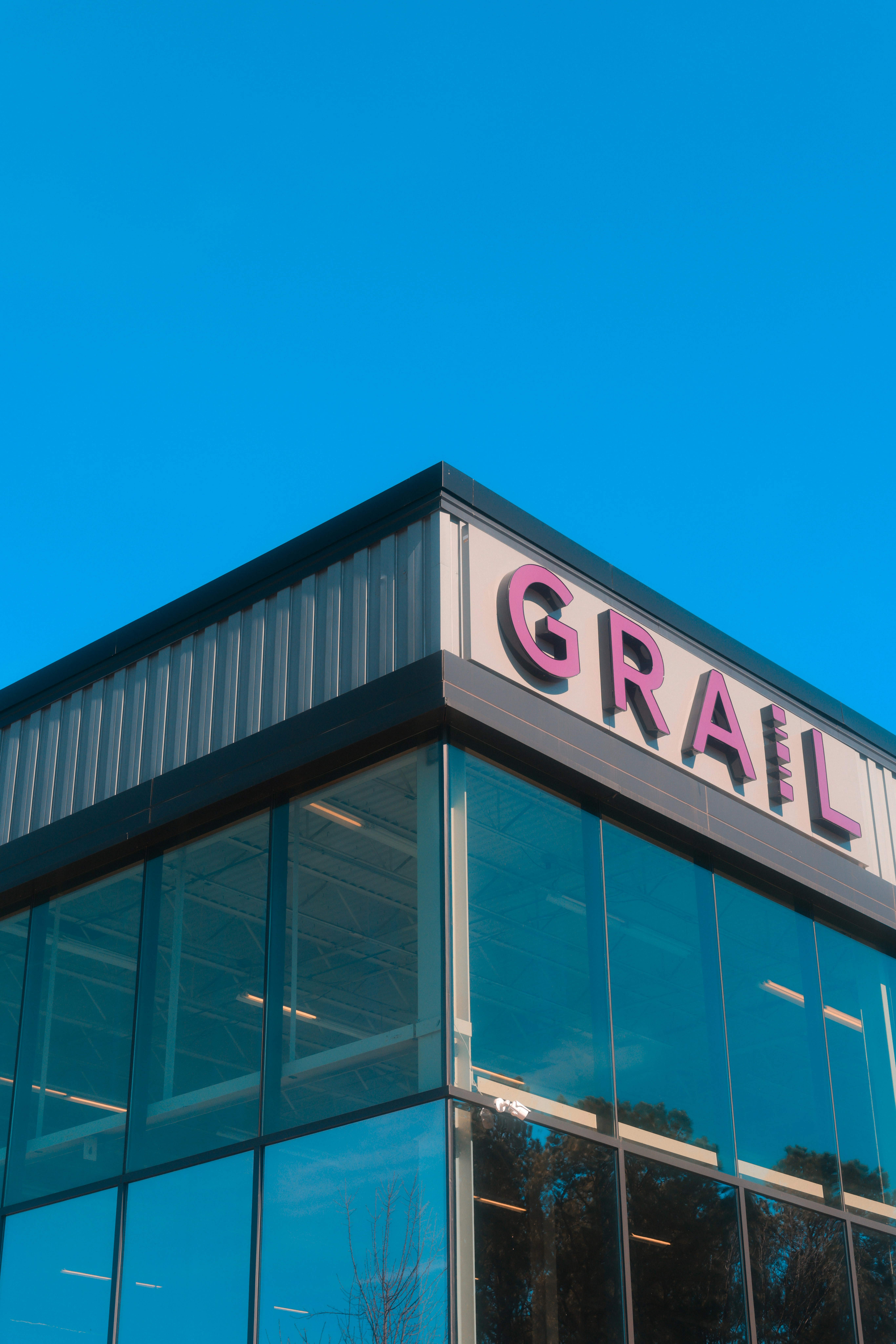 The grail sign sits atop a glass building. photo – Free Car Image on ...