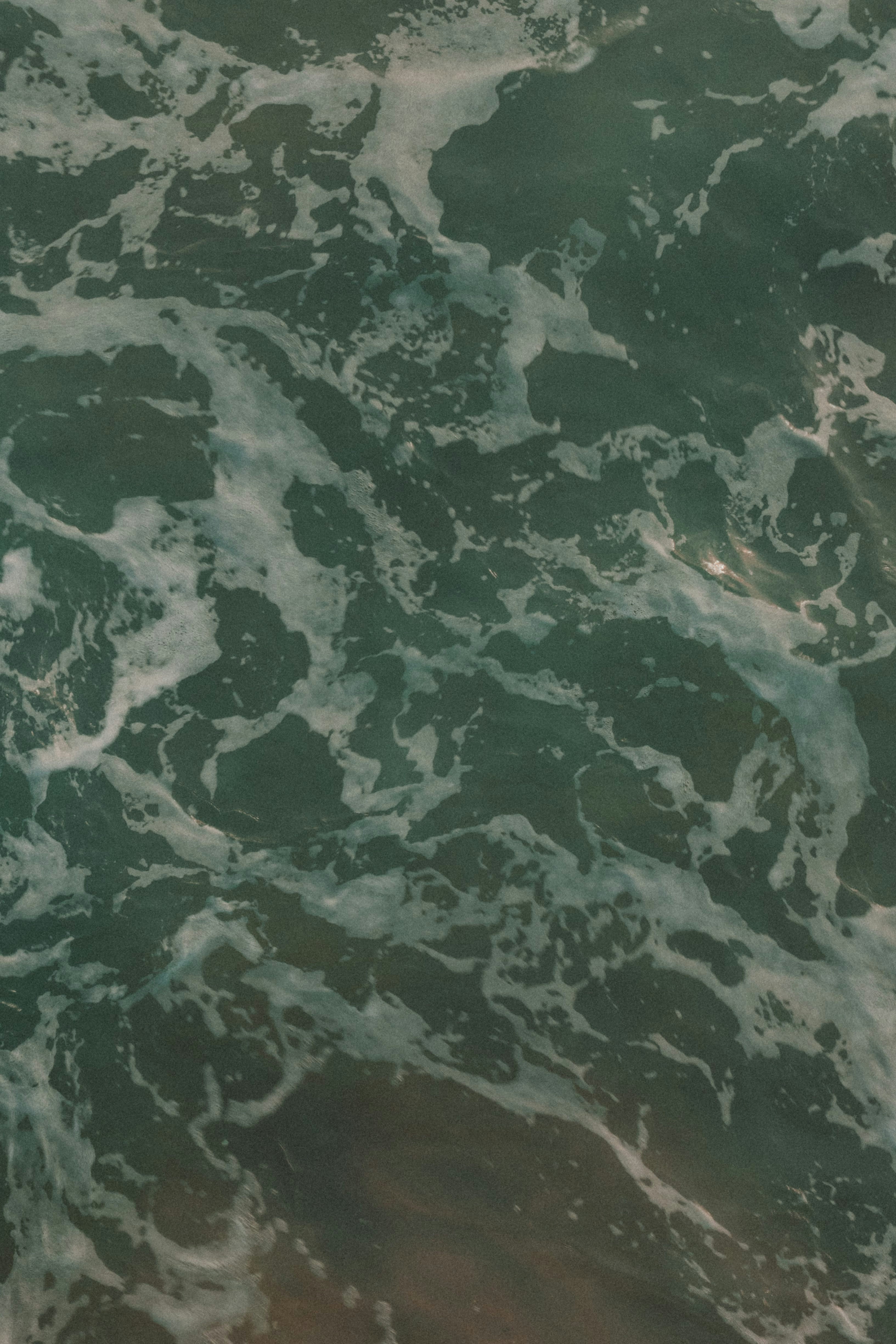 Foamy ocean water swirls around, up close. photo – Free Sea Image on ...