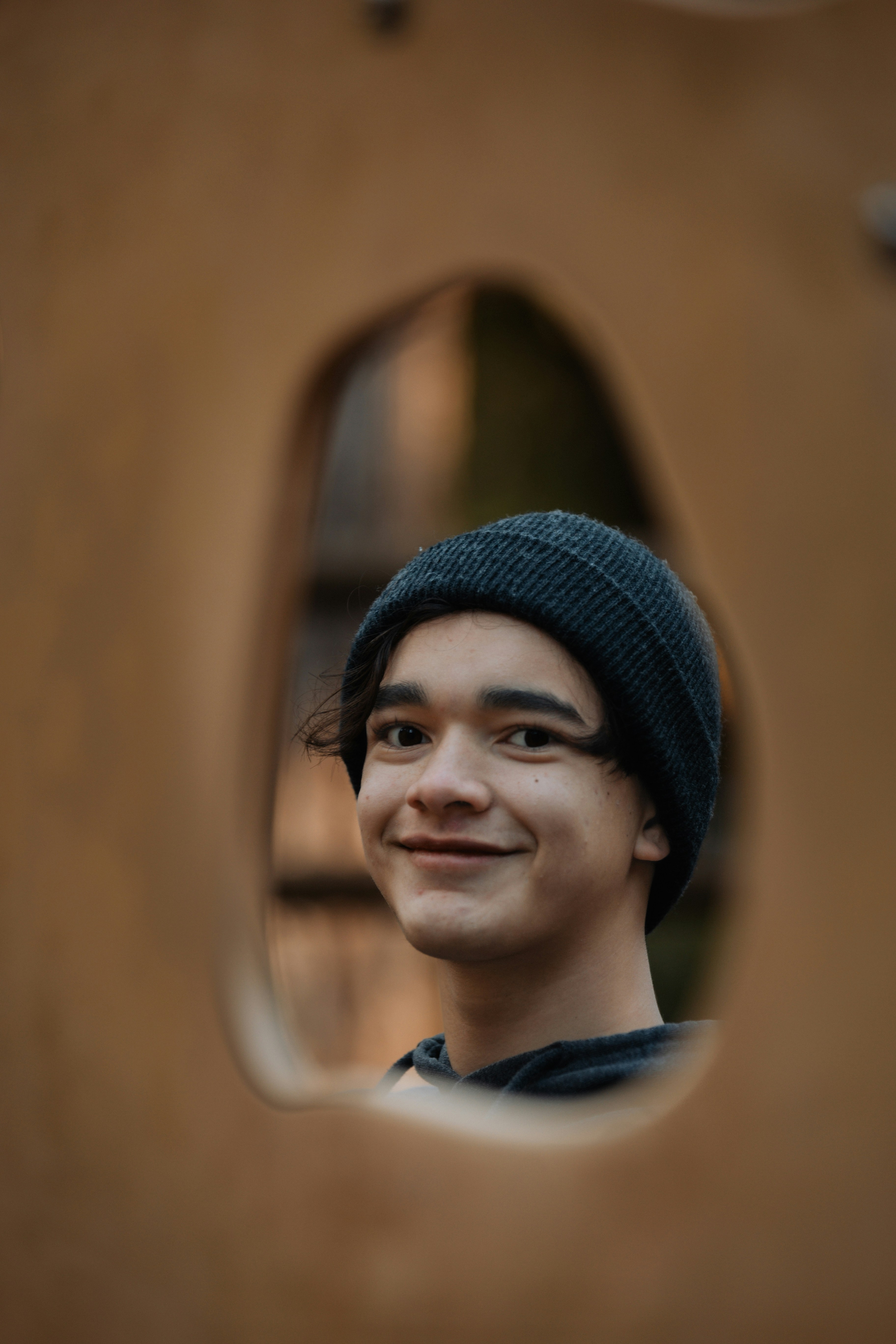 Rusted Oval Portrait: A Gentle Smile Framed by Grain and Light