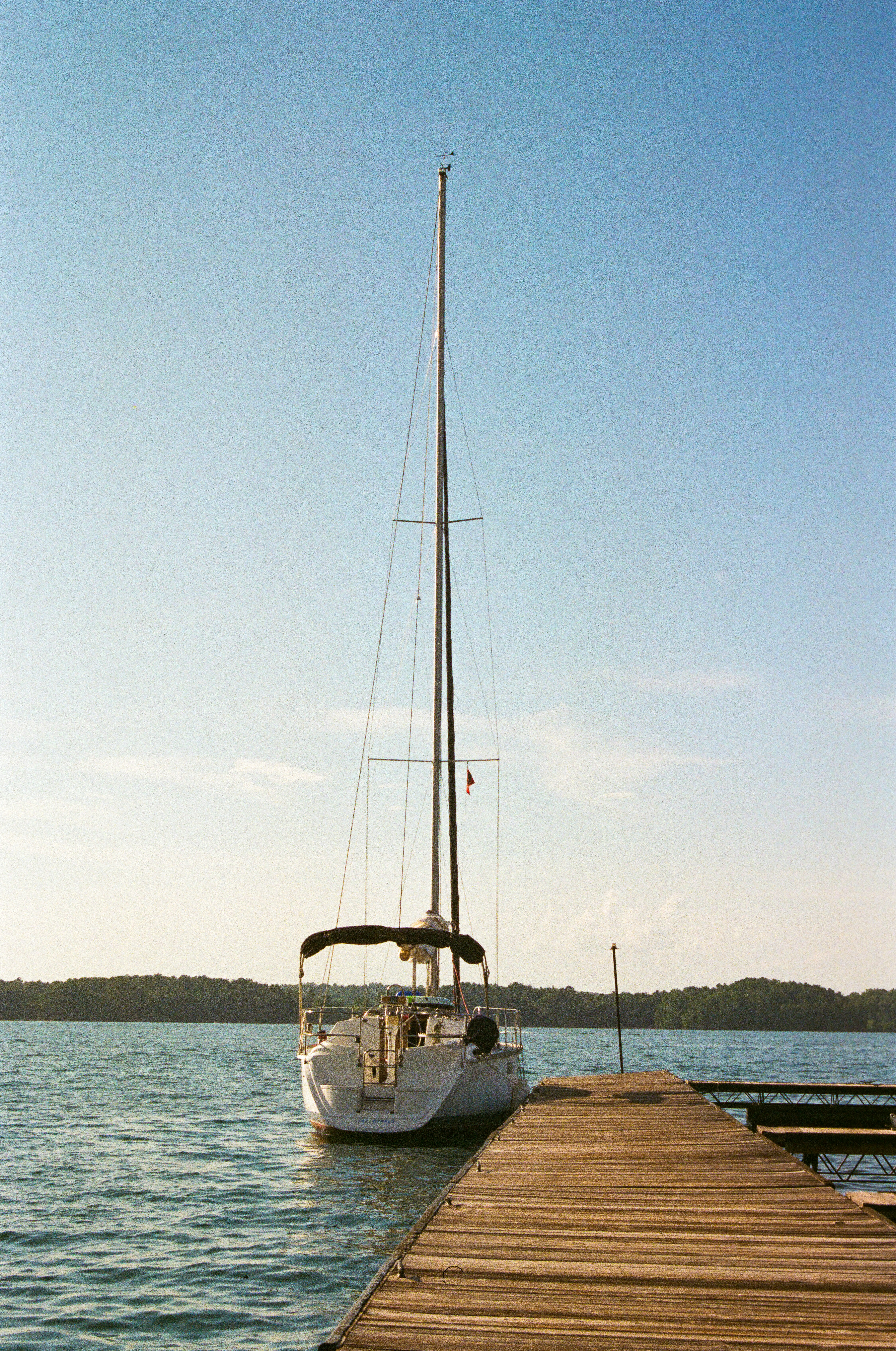 A sailboat is docked at the end of a pier. photo – Free Beach Image on ...