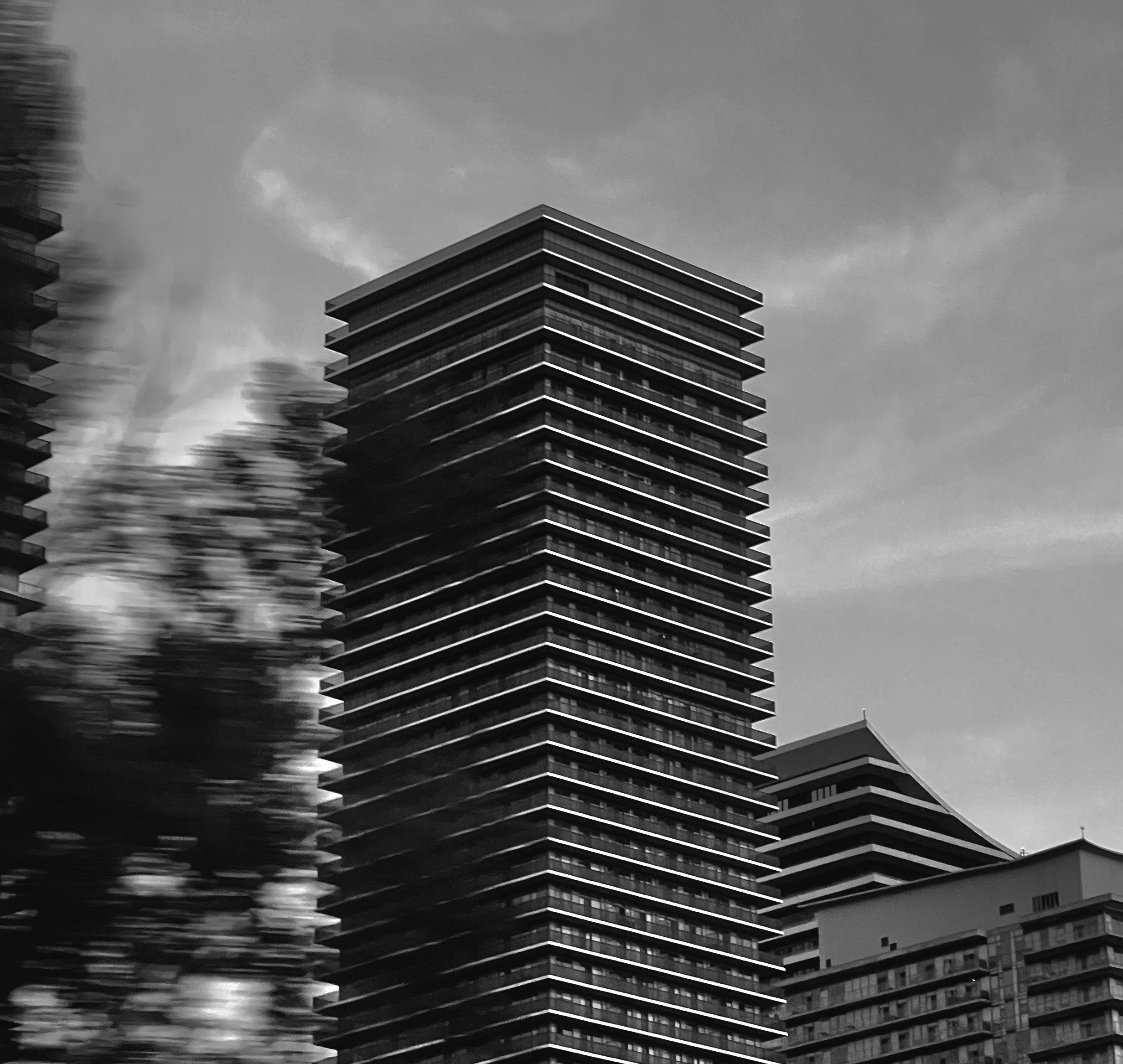 Slatted Monolith in Transit: A Skyline in Blur