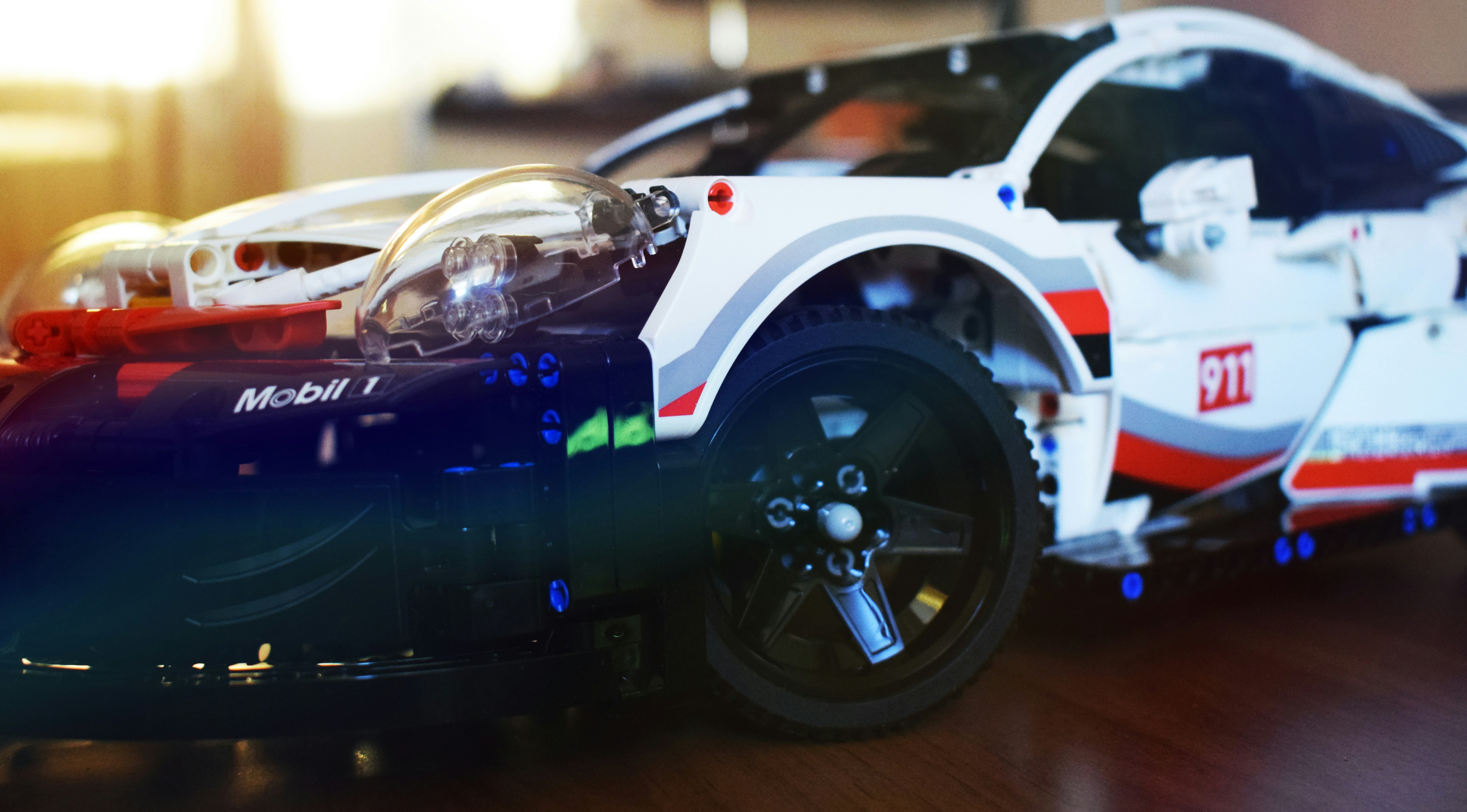 Close-up of a LEGO Technic Porsche 911 model in natural light, highlighting detailed craftsmanship.