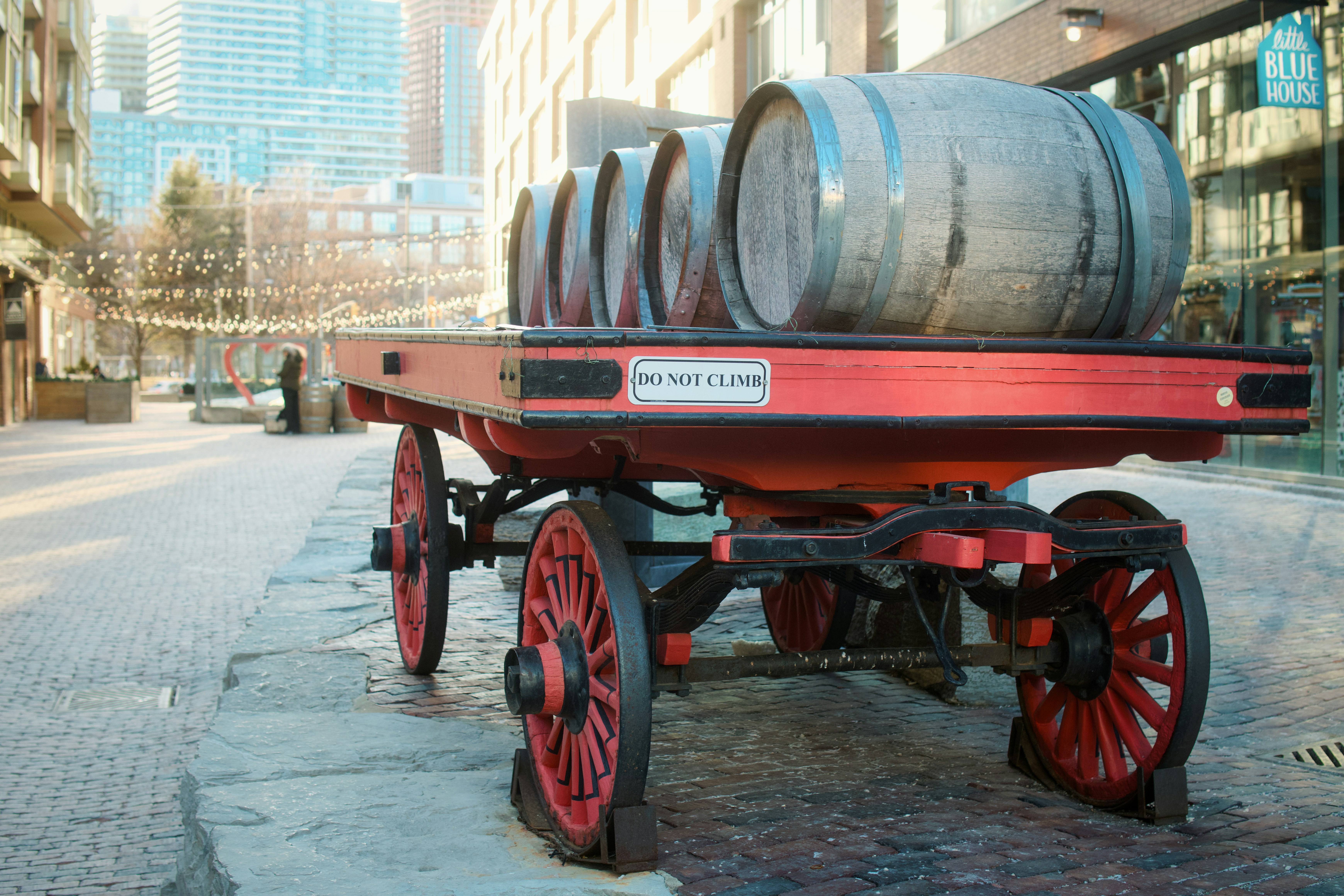 Wine barrels sit on a red wagon.