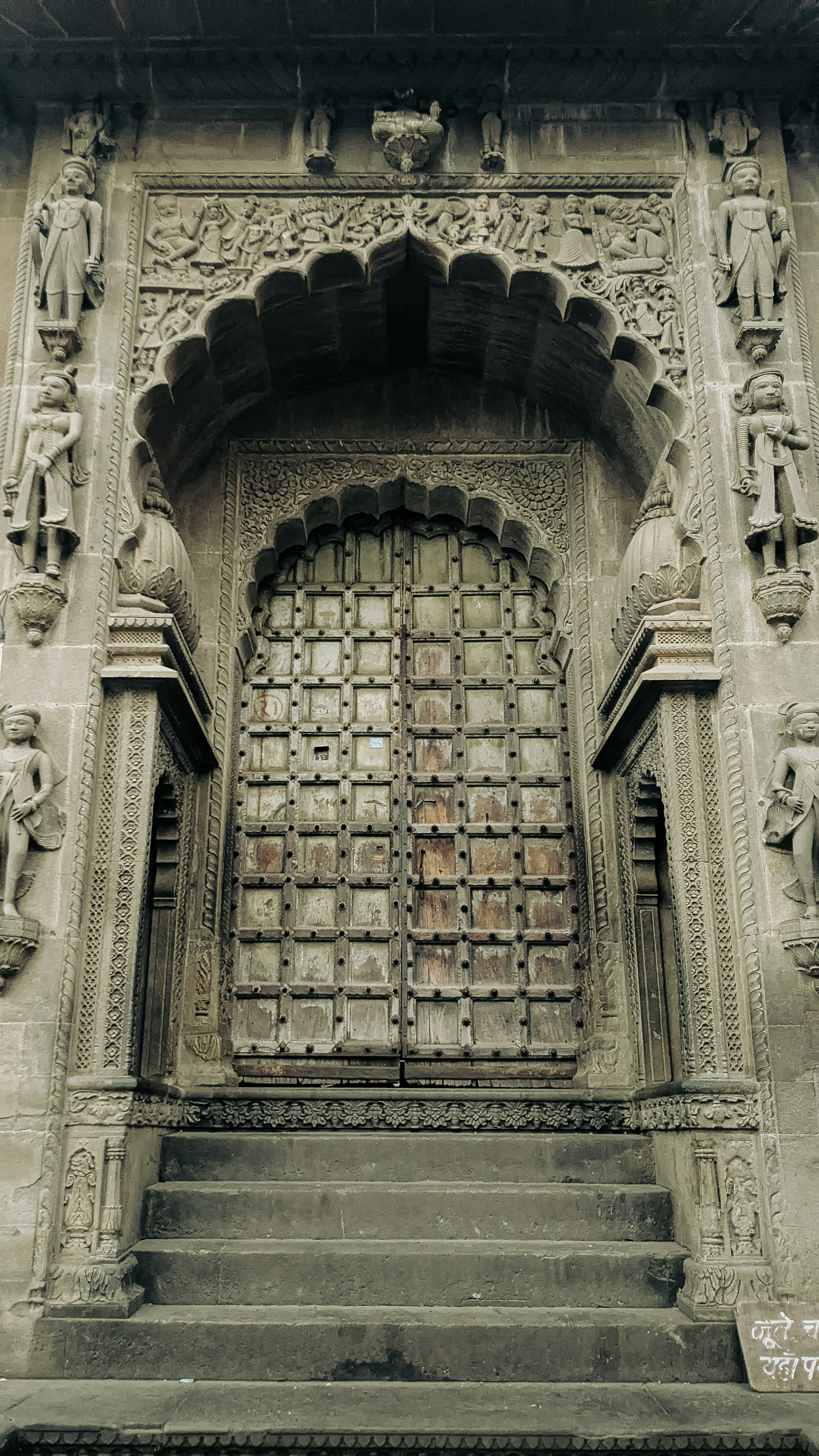Threshold of Stone: Carved Temple Door Framed by Guardian Figures