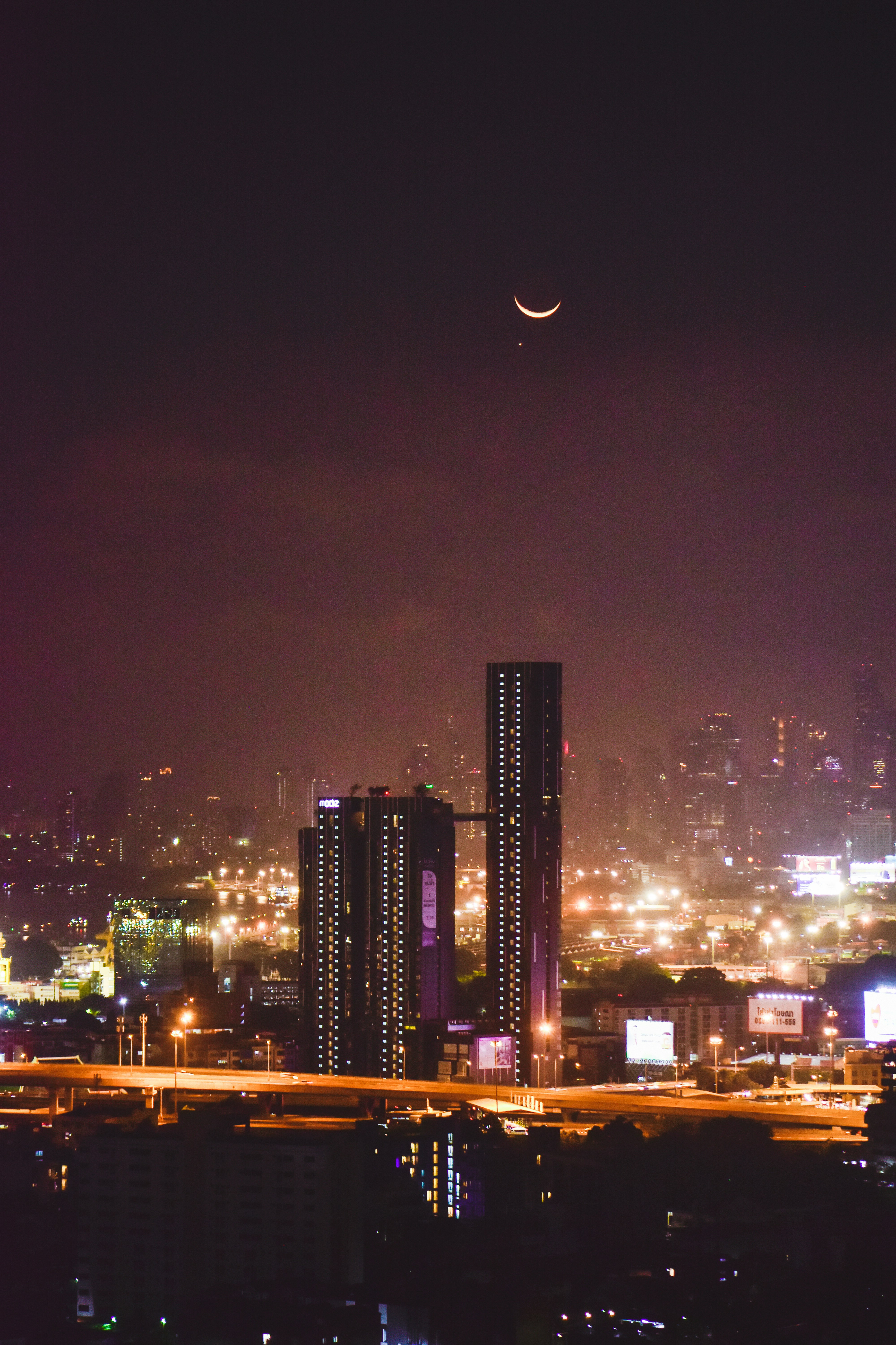 Moonlit Crescent Above Neon Spine: Nightscape Over a City of Light