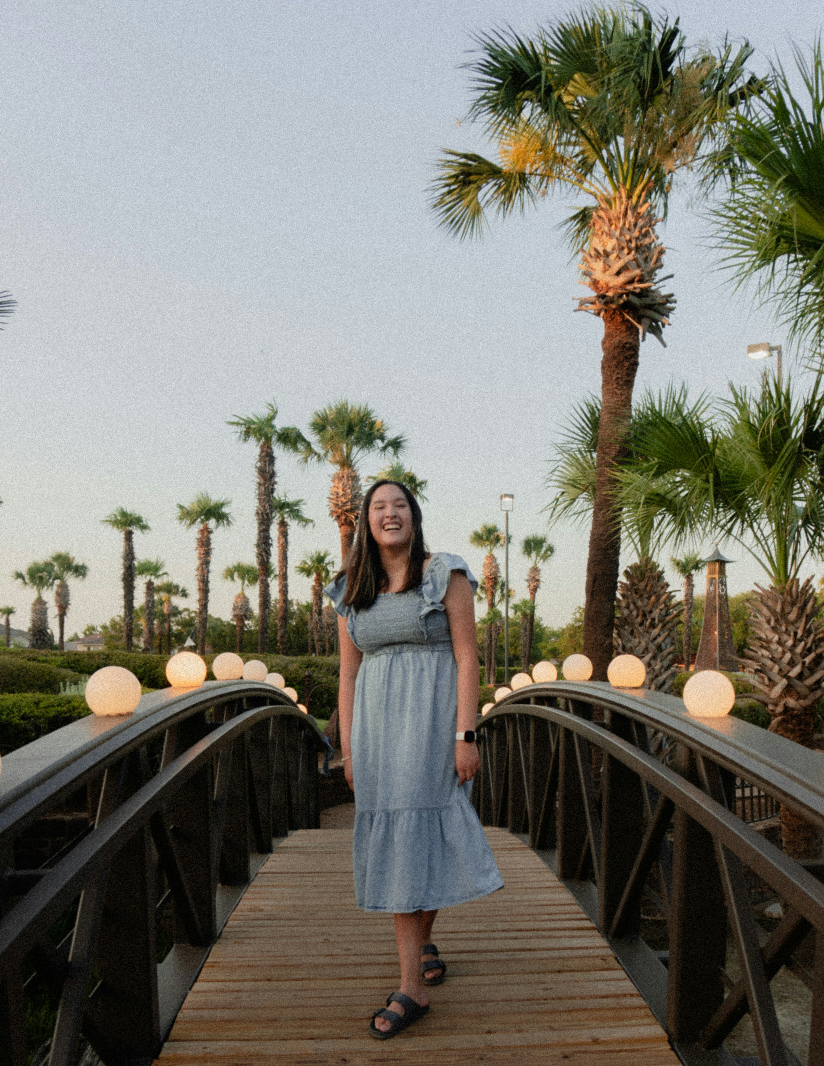 Orbs and Palms: Golden Hour Portrait on a Palm-Lined Bridge