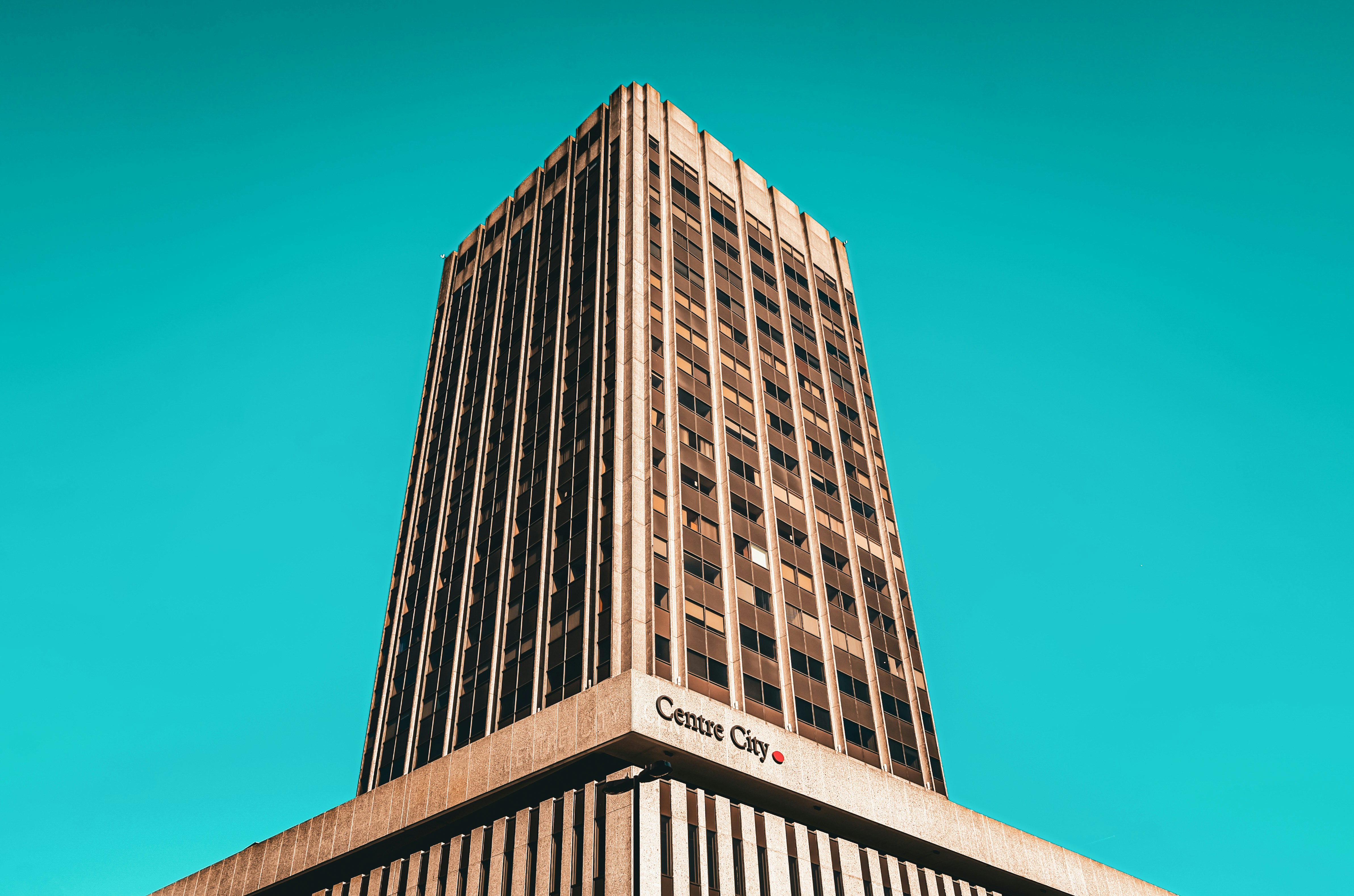 Tall brown building set against a vibrant turquoise sky.