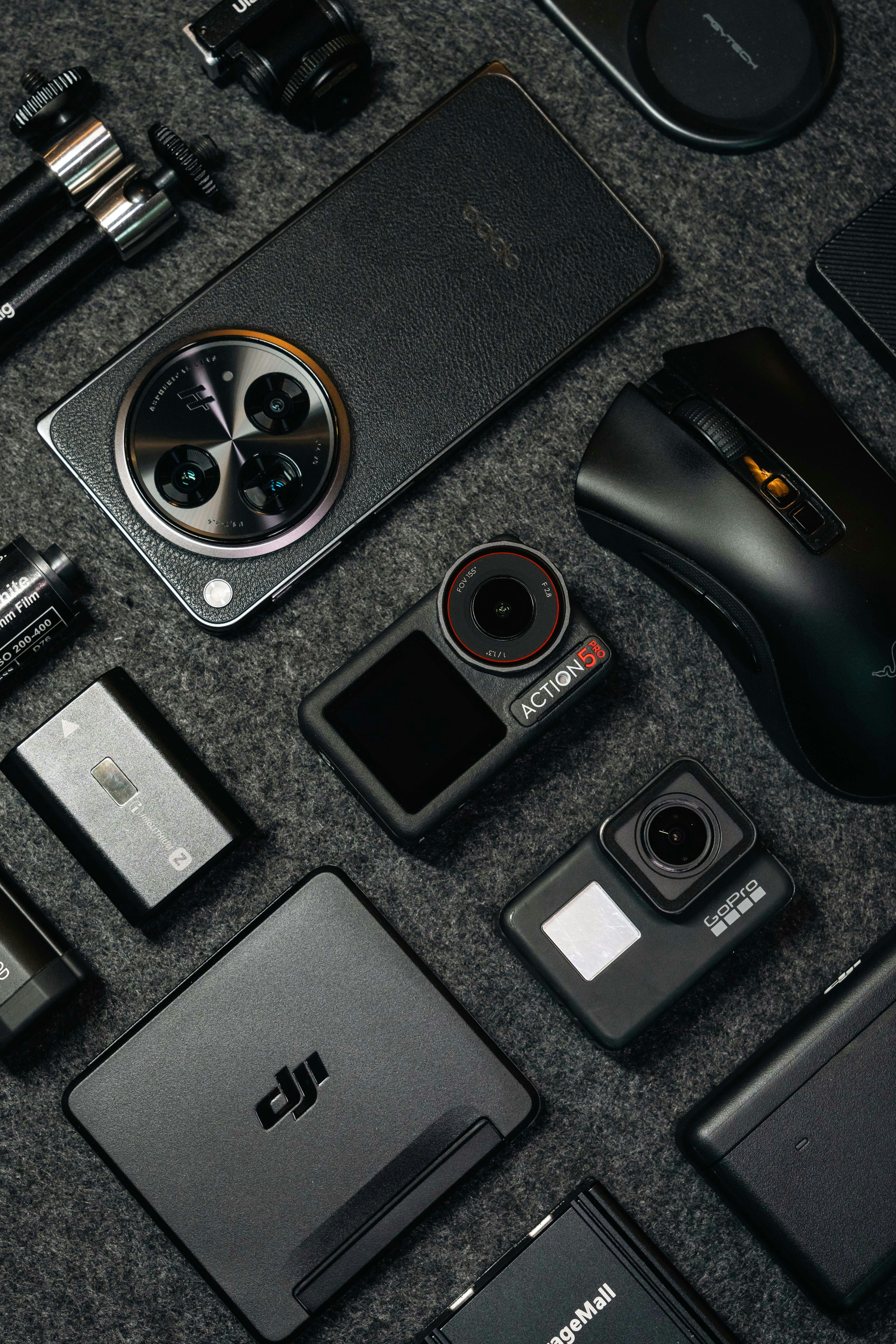 Gear Grid: Flat-Lay of Action Cams, Chargers, and a Sleek Smartphone with a Circular Camera Ring
